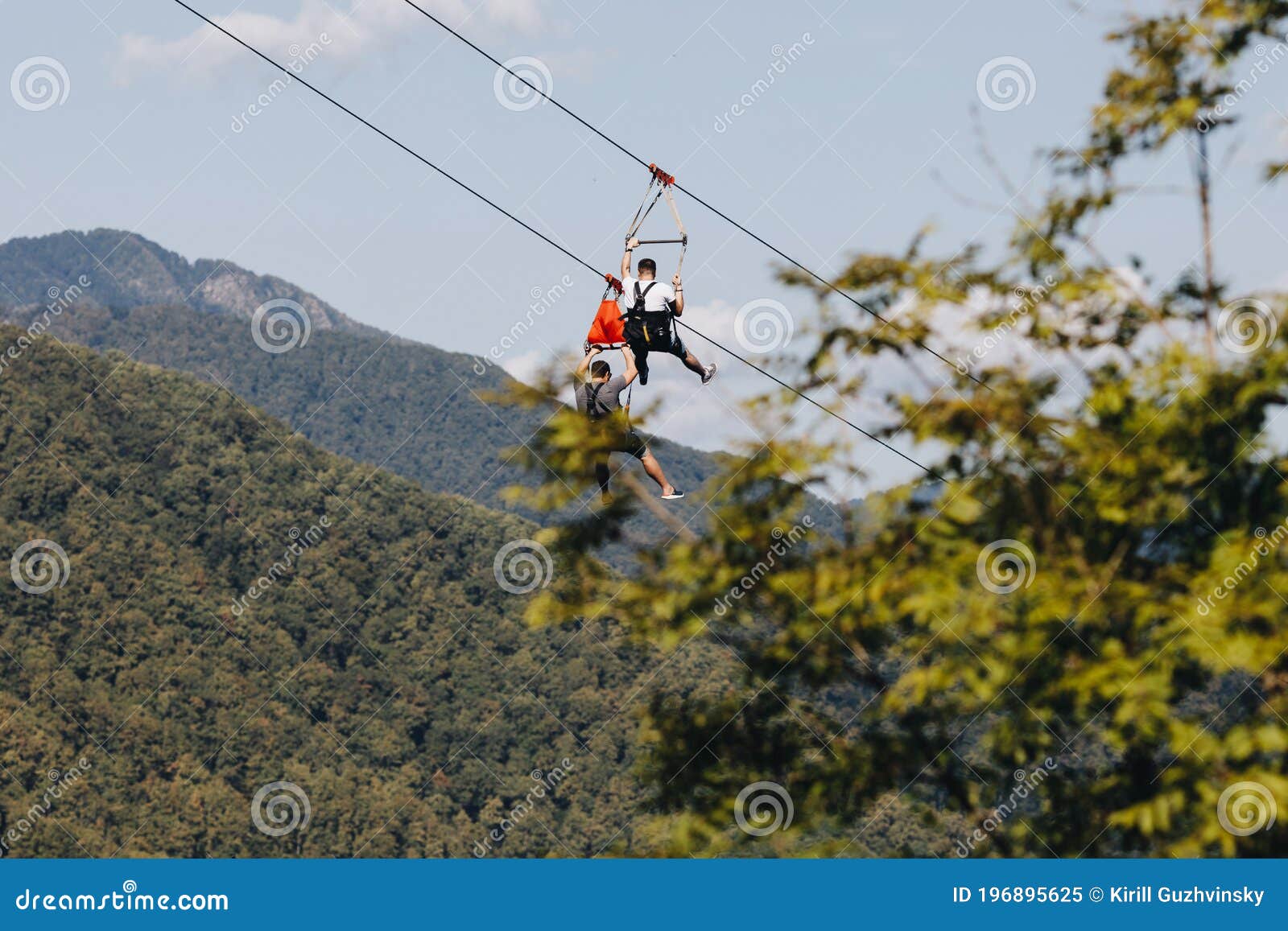 A Brave Man Descends on a Zip Line High in the Mountains Above the ...