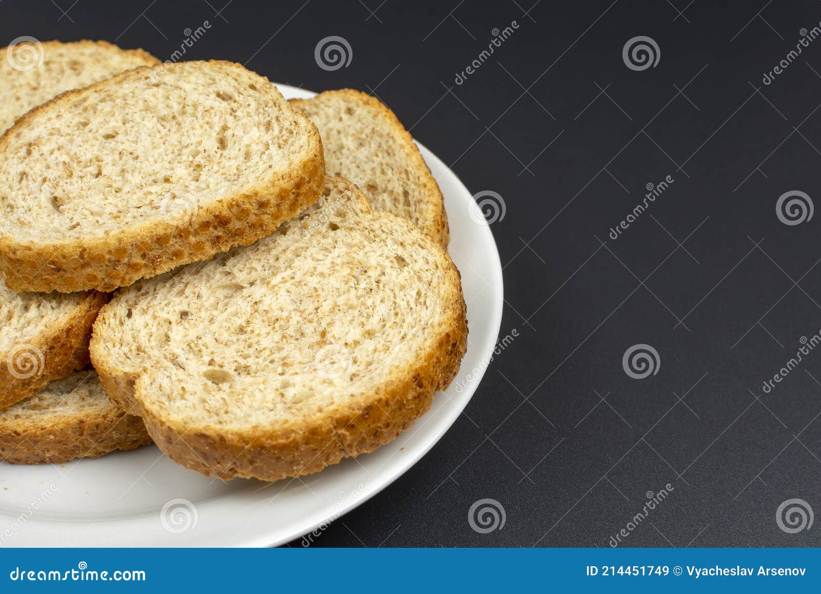 Bread Dried in the Oven on a White Ceramic Plate on a Black Background ...