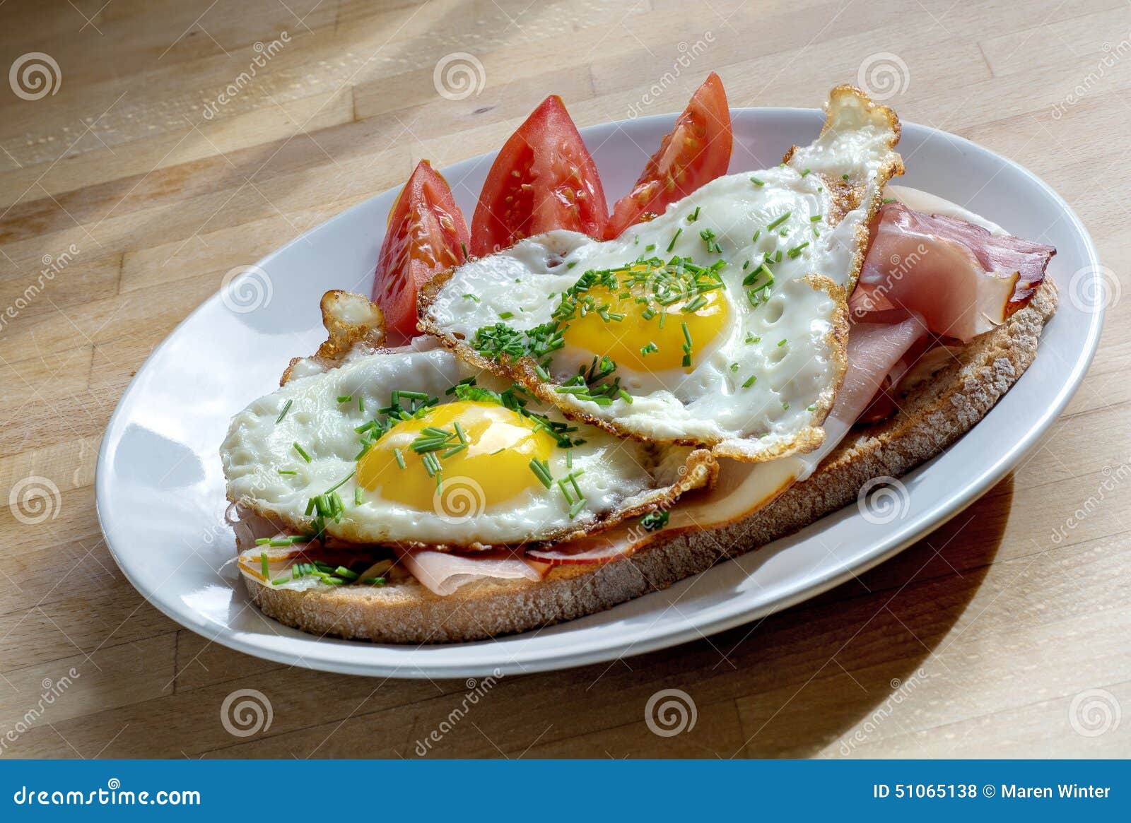 Bread with Ham and Fried Egg Garnish with Chives on a Plate Stock Photo ...