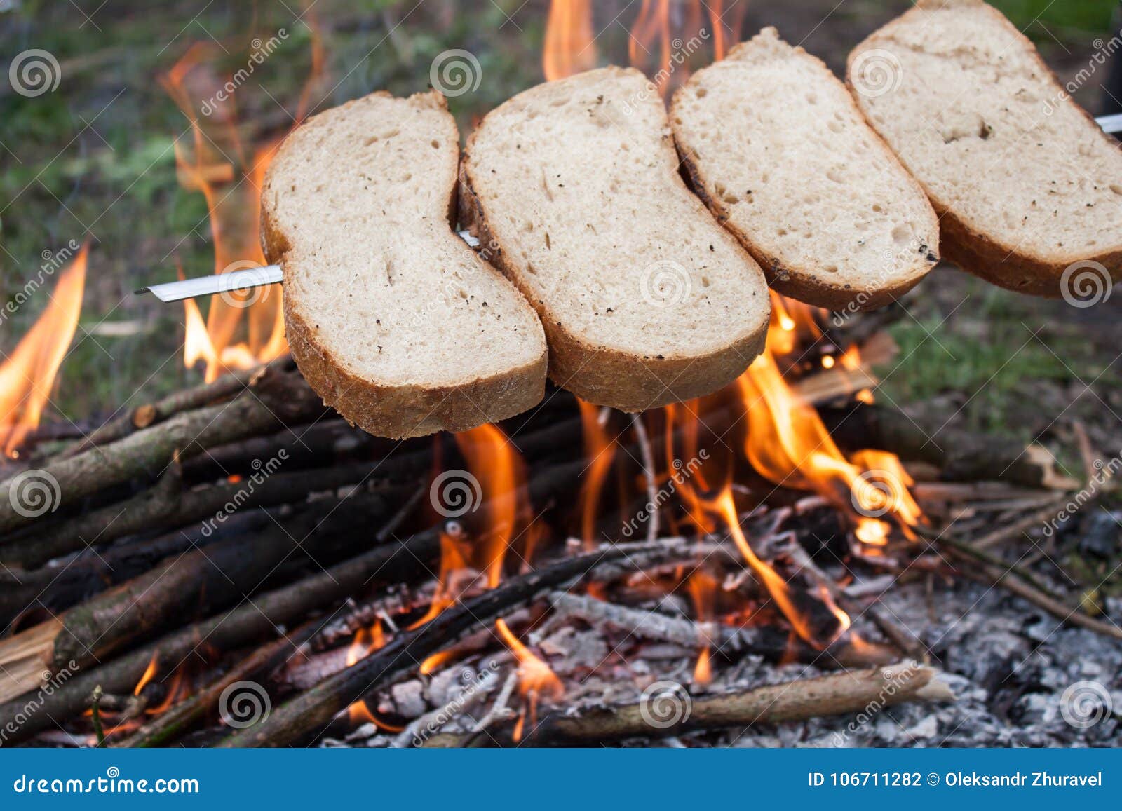 Bread roasting on the fire stock photo. Image of bonfire - 106711282