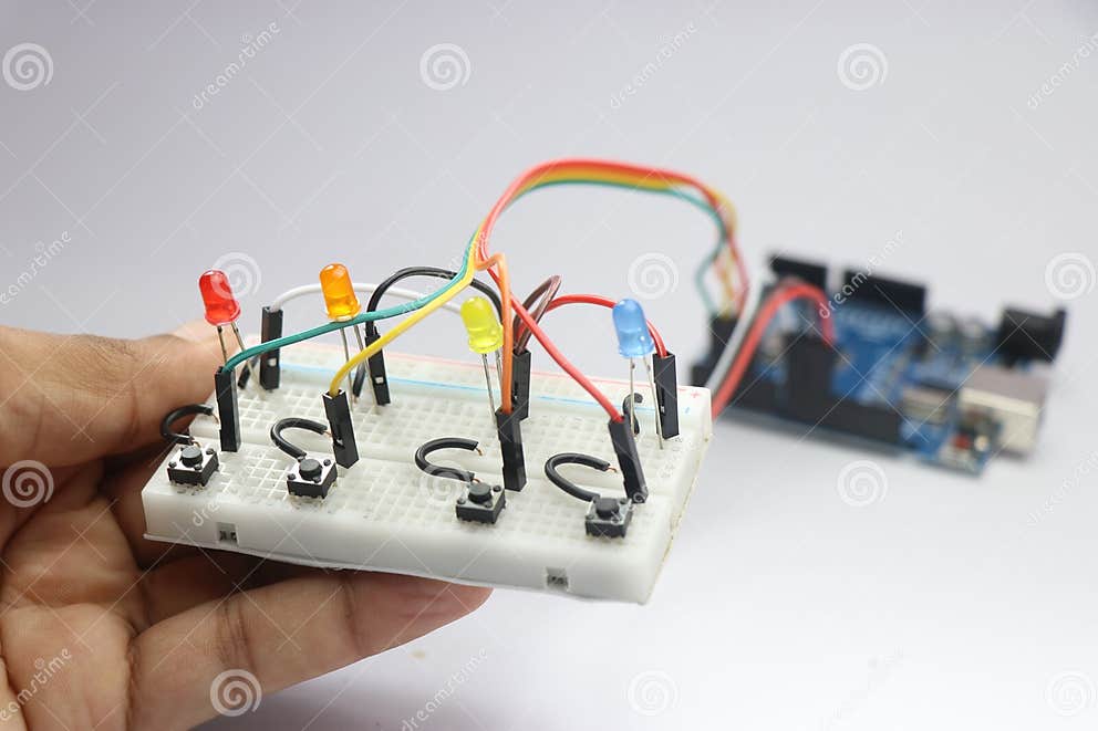 Breadboard with Toggle Switch and LED Connected with Jumper Cables Held ...