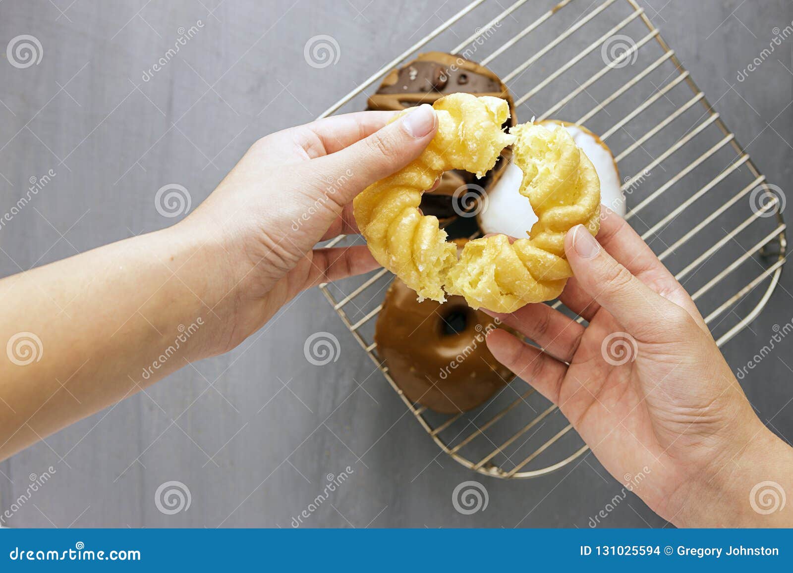 Breaking apart a donut. stock photo. Image of glazed - 131025594