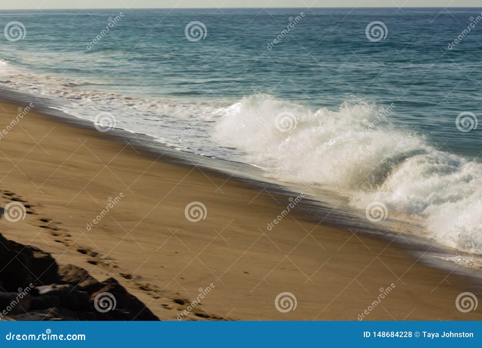 Breaking Wave on Sandy Beach, with Backwash, Footprints and Rocks Stock ...