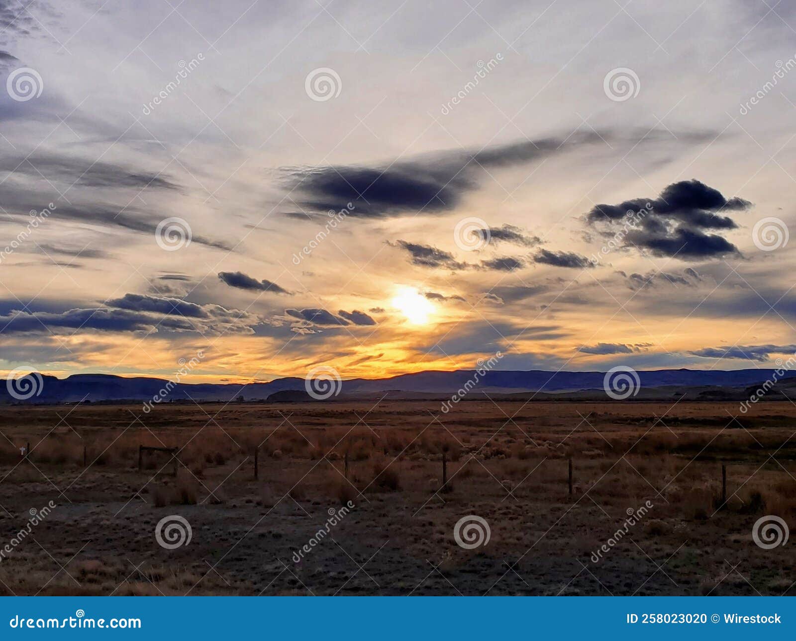Breathtaking View of Bright Sunset Clouds Ver Brown Field with ...