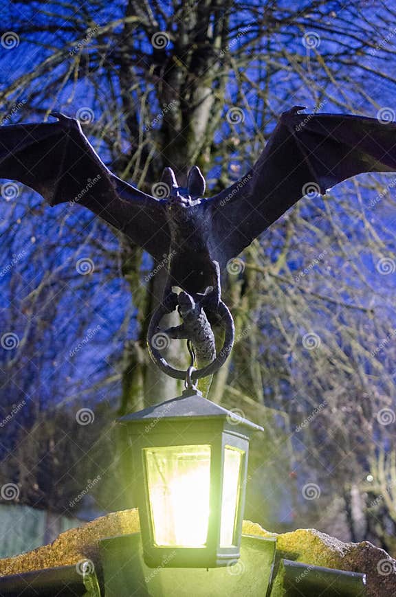 The Statue of a Bat with a Flashlight in Its Paws at Night. Stock Photo ...