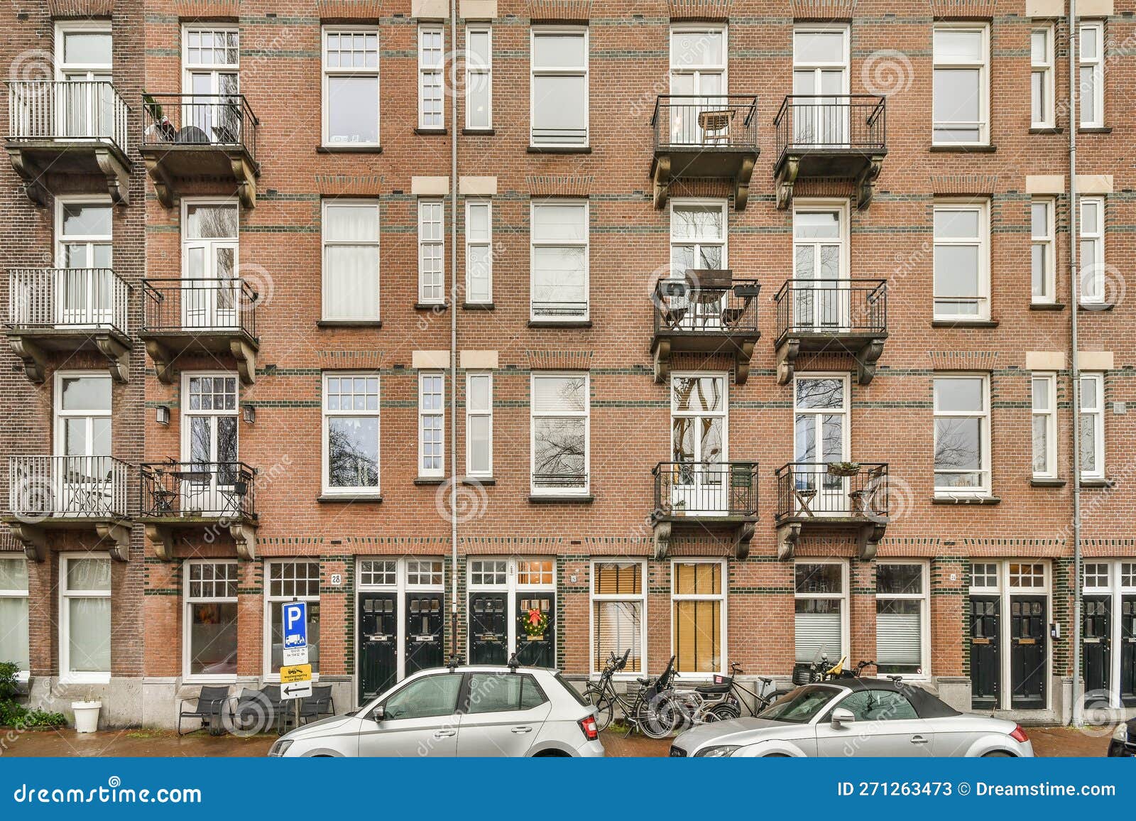 A Brick Apartment Building with Cars Parked Outside of it Editorial ...