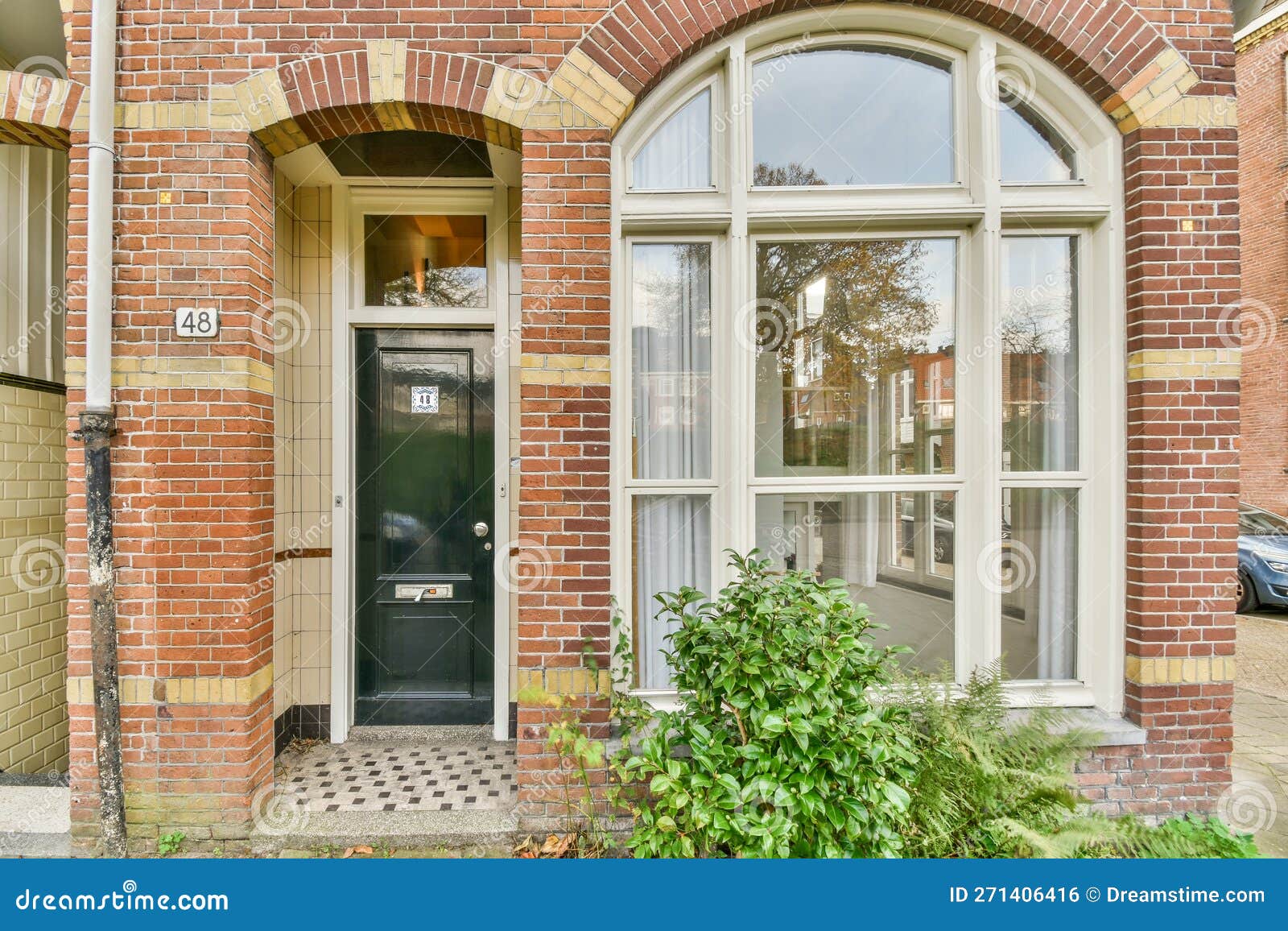 A Brick House with Large Windows and a Black Door Editorial Photo ...