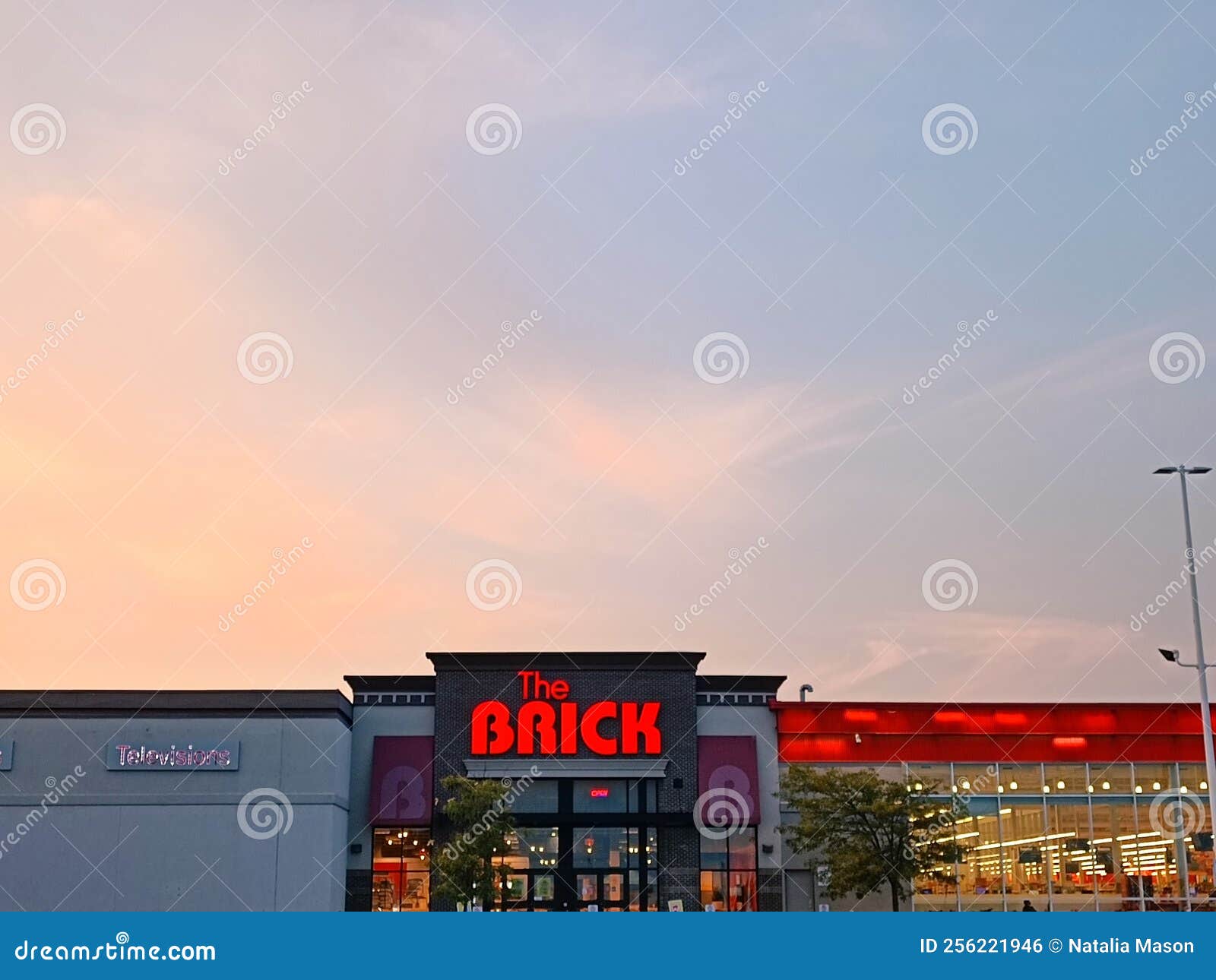 A Red Brick Store Front With Concrete Pillars And Arches And Arched ...