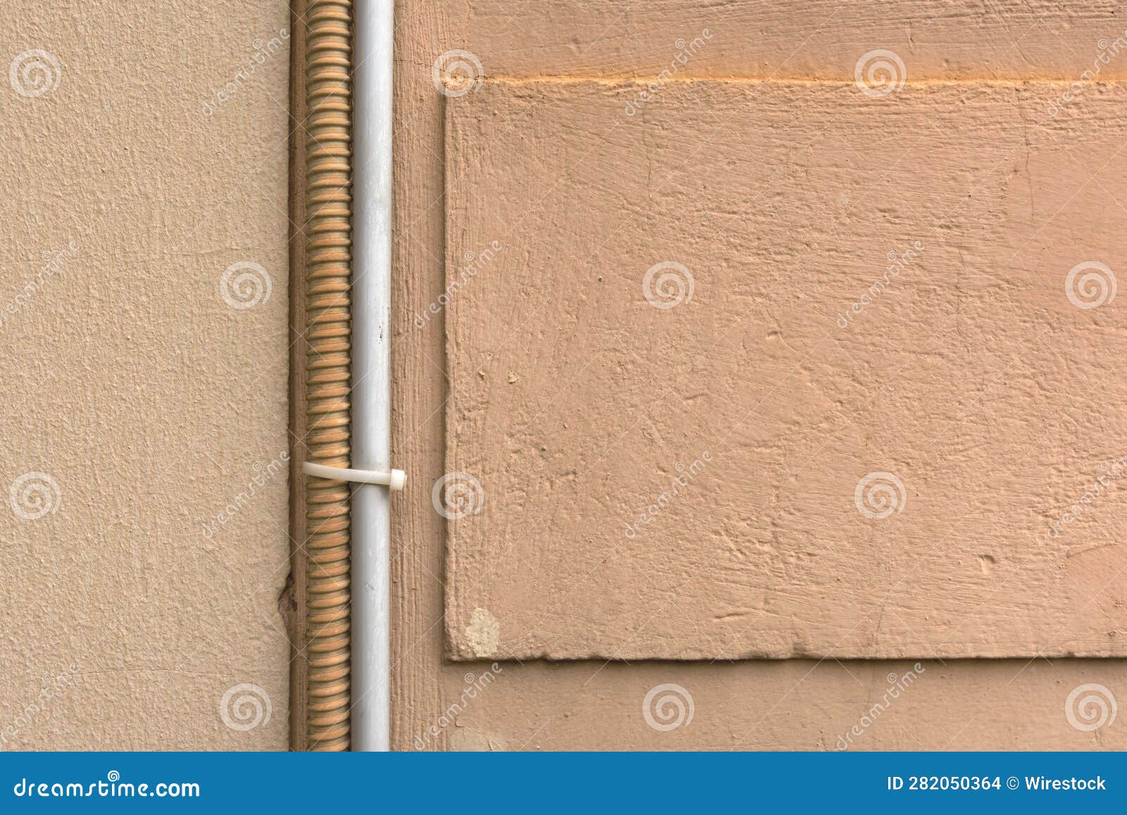 Brick Wall of a Building with Pipes, Illuminated by a Warm Yellow Light ...