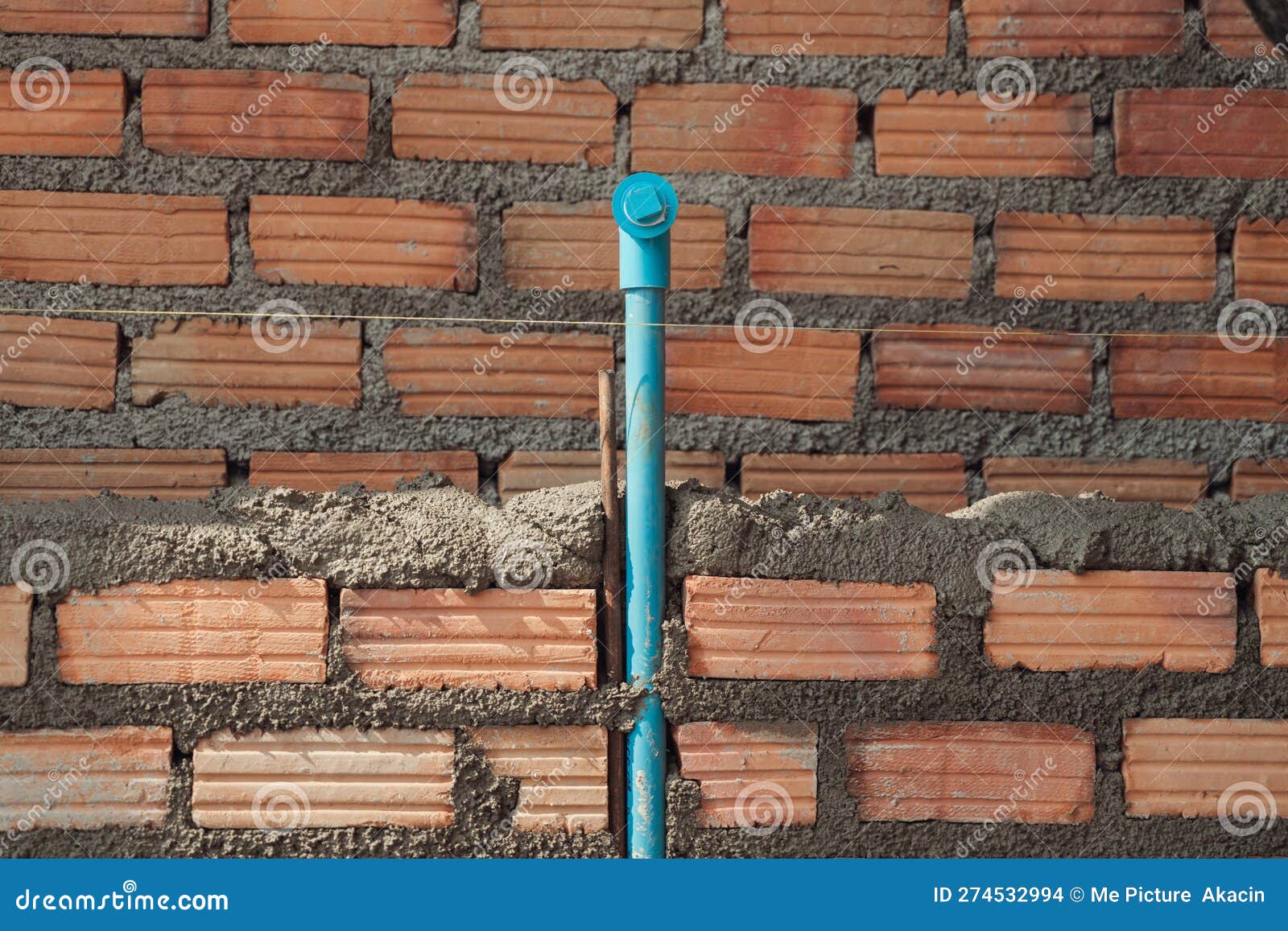 Bricklayer Installing Red Bricks Masonry and PVC Pipe in a New Wall ...