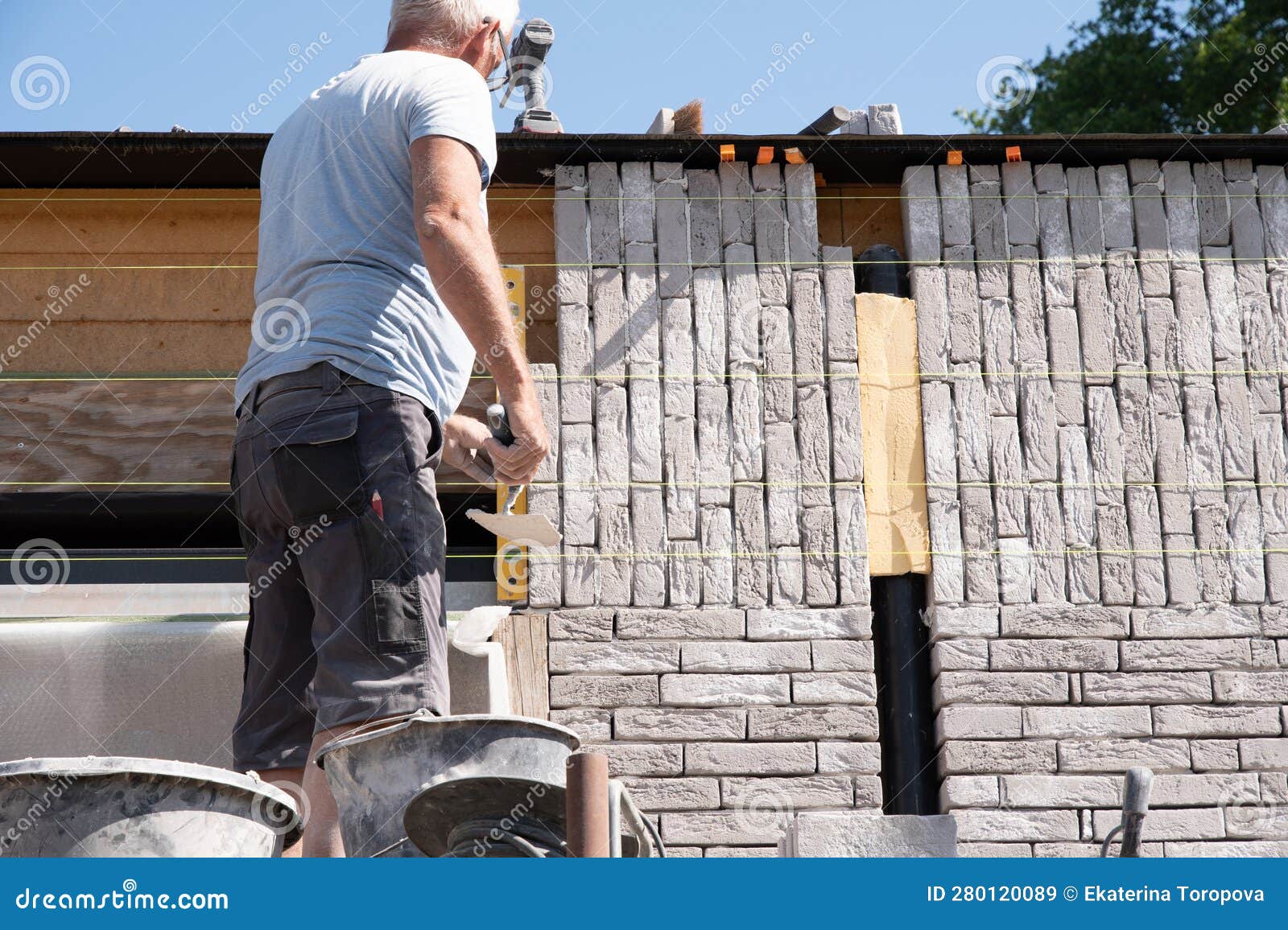 Masonry Worker the Bricklayer Makes the Facade of the House from Gray ...