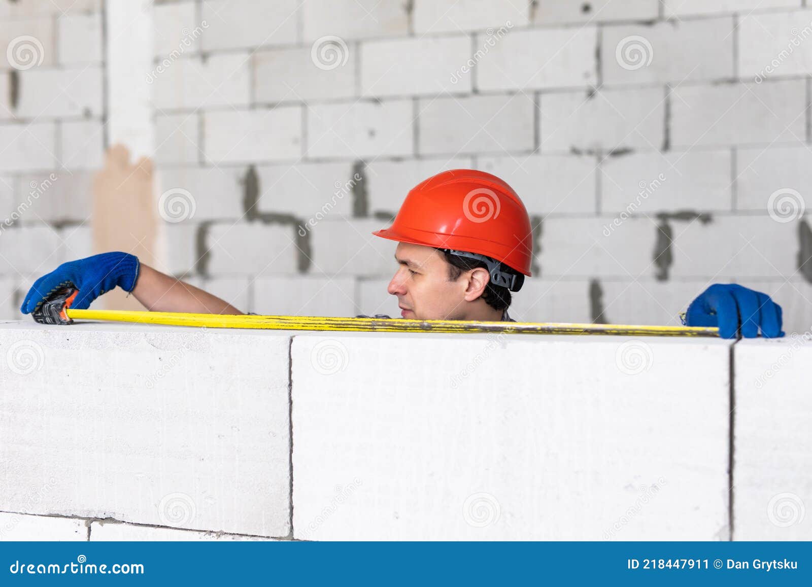 The Bricklayer Measures a Newly Built Wall with a Tape Measure Stock ...