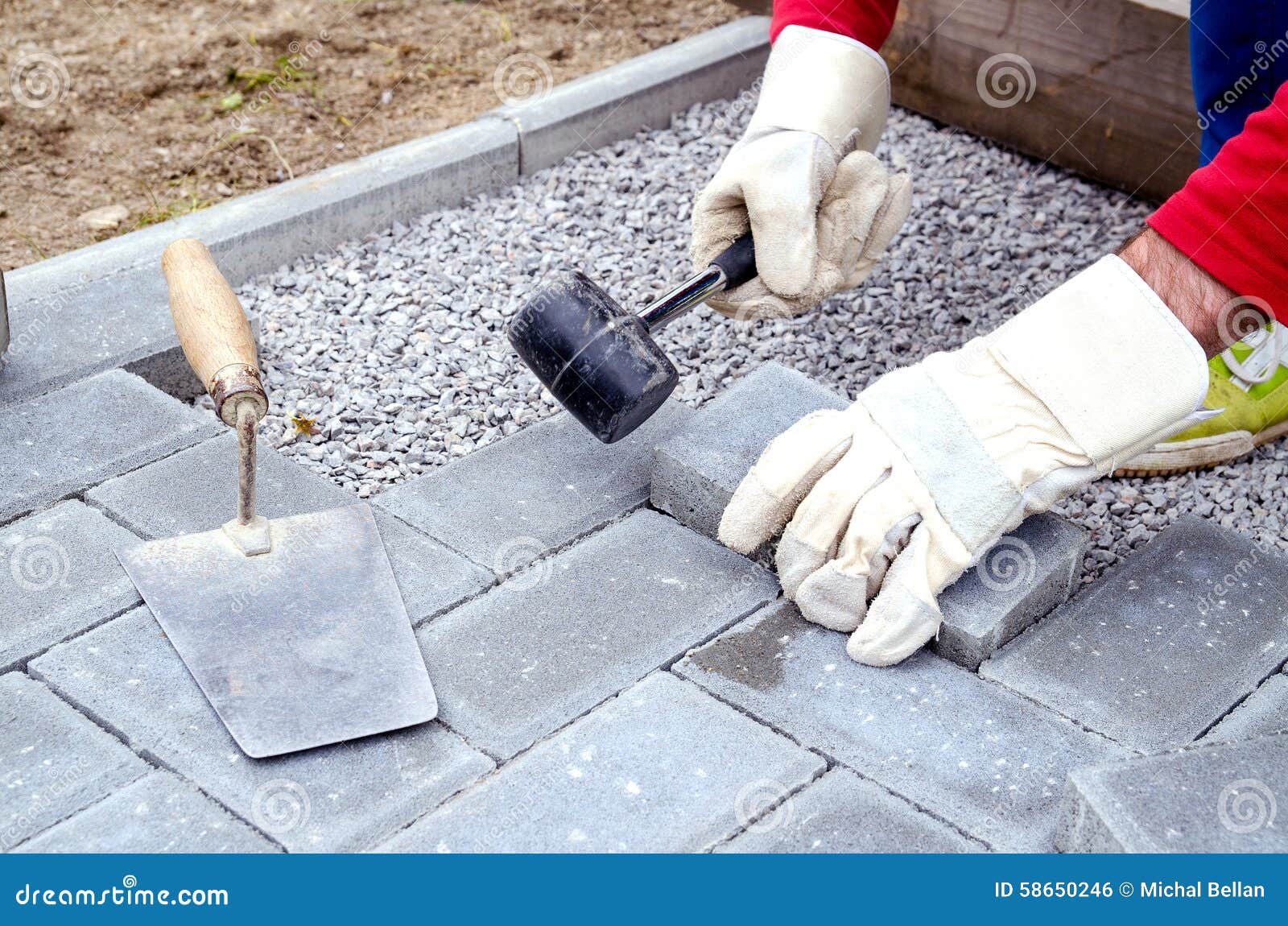 Bricklayer Places Concrete Paving Stone Blocks for Building Up a Stock ...
