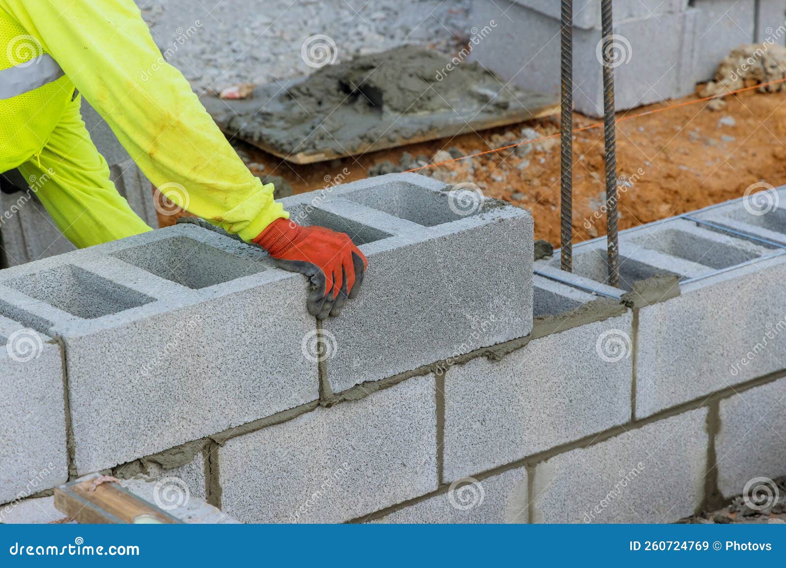 The Bricklayer is Putting Down Another Row of Cement Blocks As Part of ...