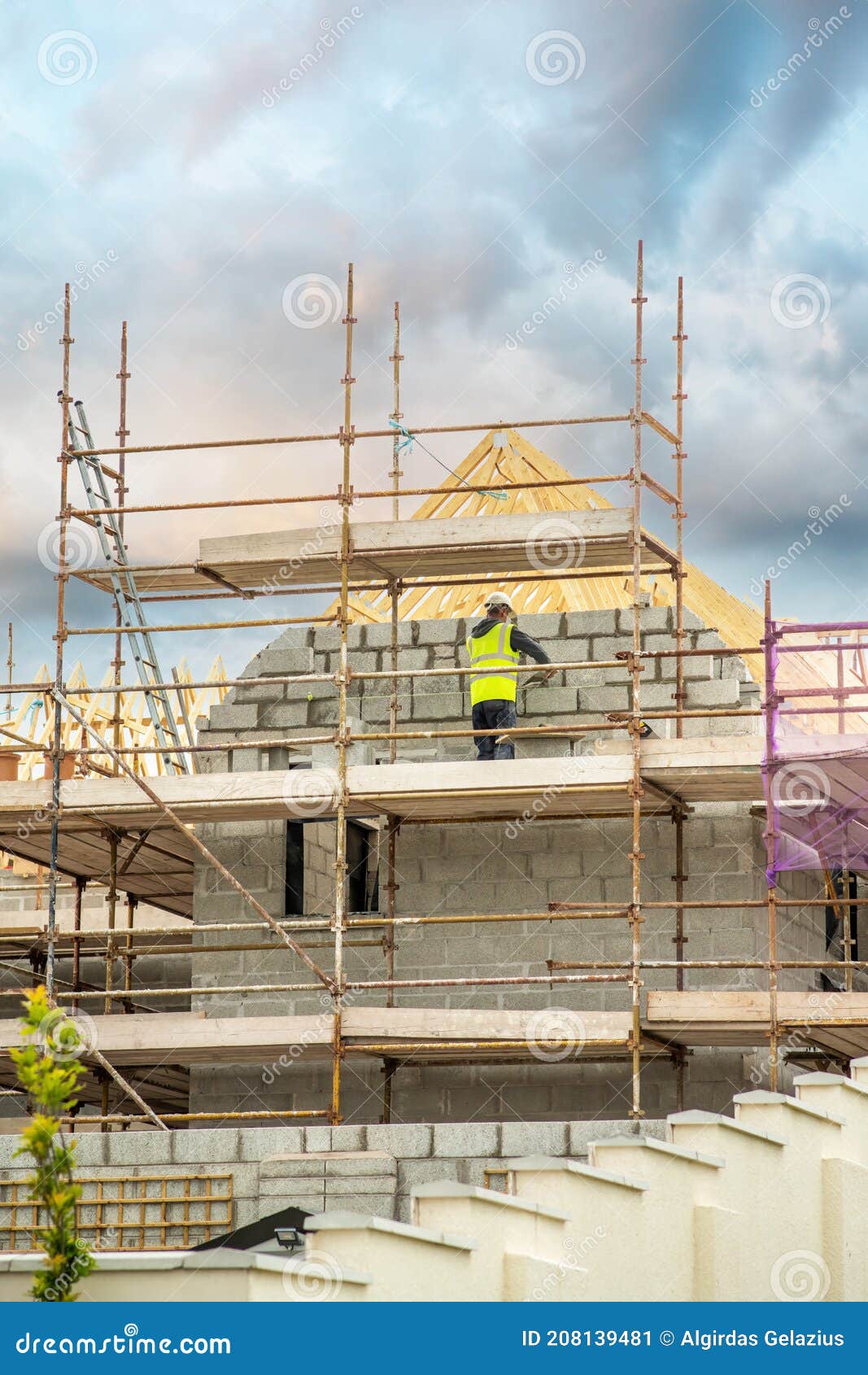 Bricklayer on a Scaffolding Brick a Wall of Concrete Blocks Stock Image ...