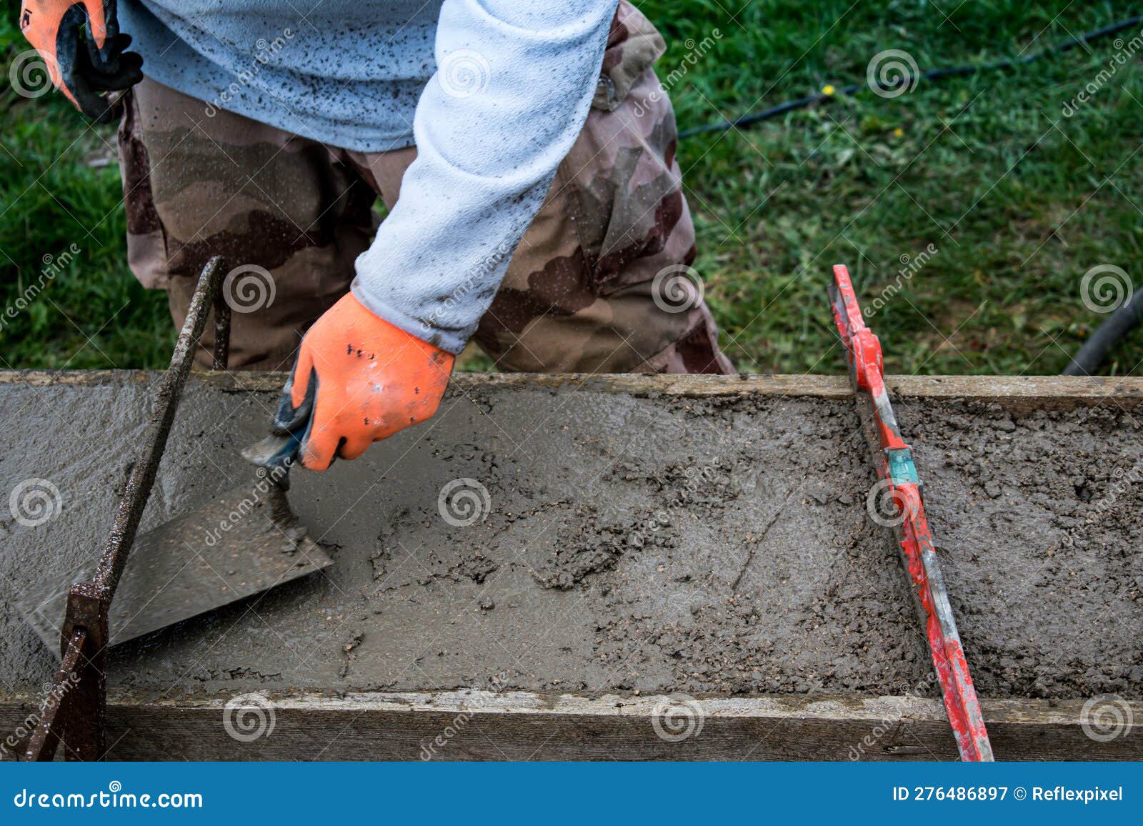 Bricklayer Spreading Concrete with a Trowel and Level To Build a Wall ...