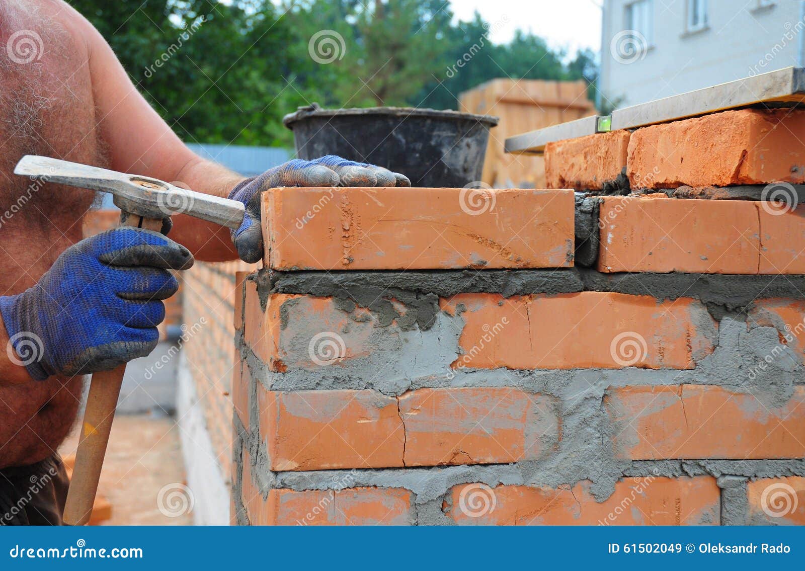 Bricklayer Using a Bricklaying Hammer To Build New Red Brick Wall ...