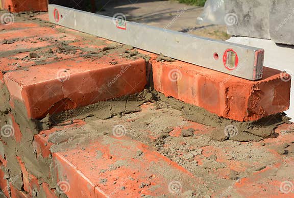 Bricklayer Using a Spirit Level To Check Bricklaying Wall Outdoors ...