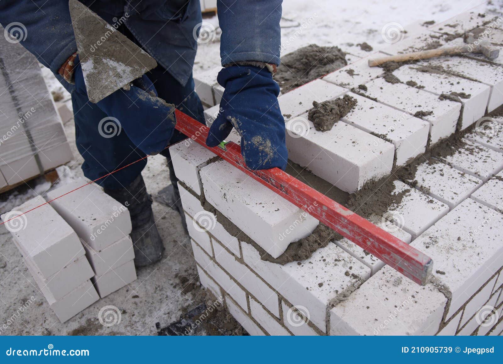A Bricklayer Works on a Construction Site, Laying Concrete Blocks ...