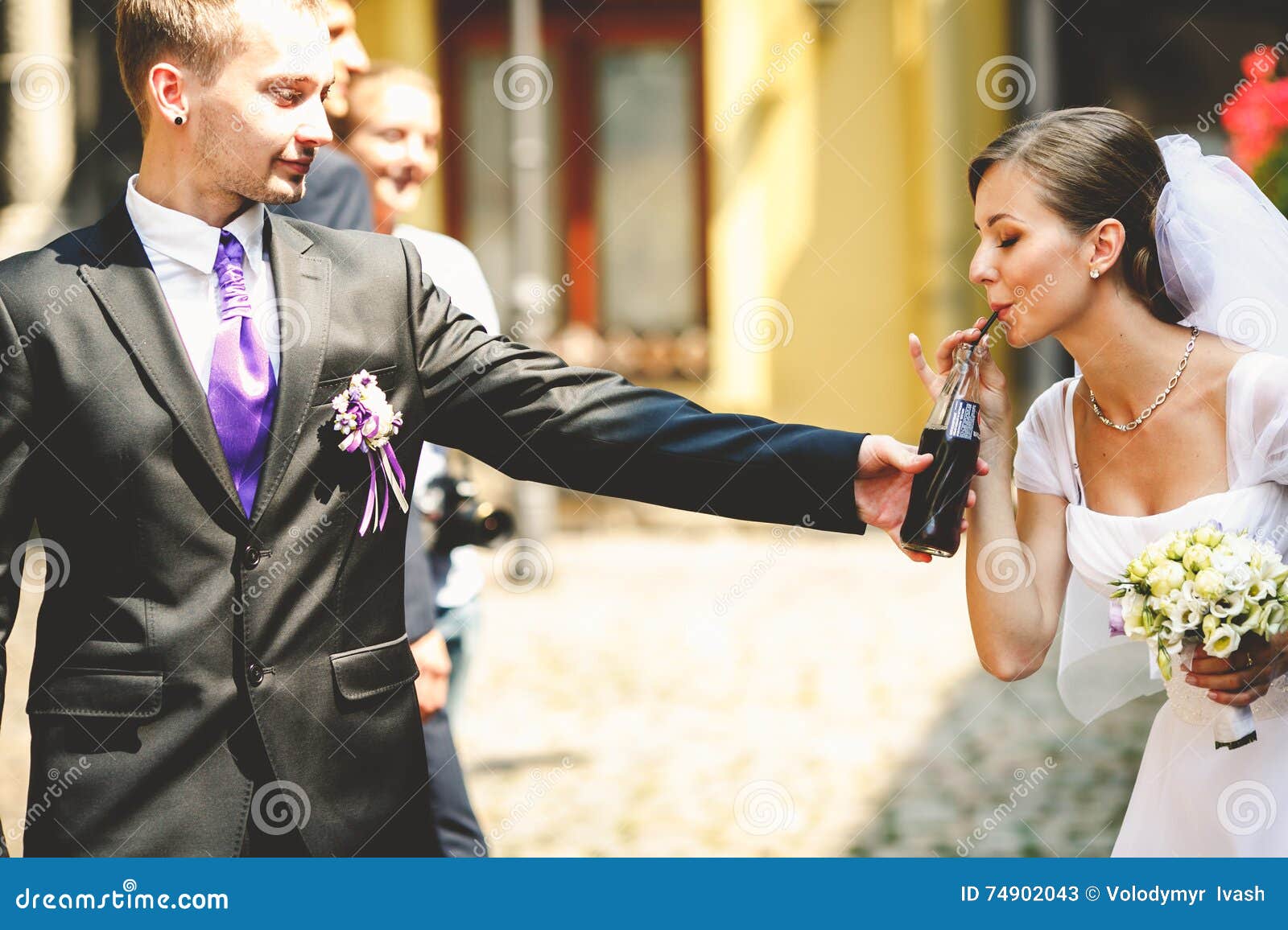 Bride Drinks Soda from a Bottle Held by Groomsman Stock Image - Image ...