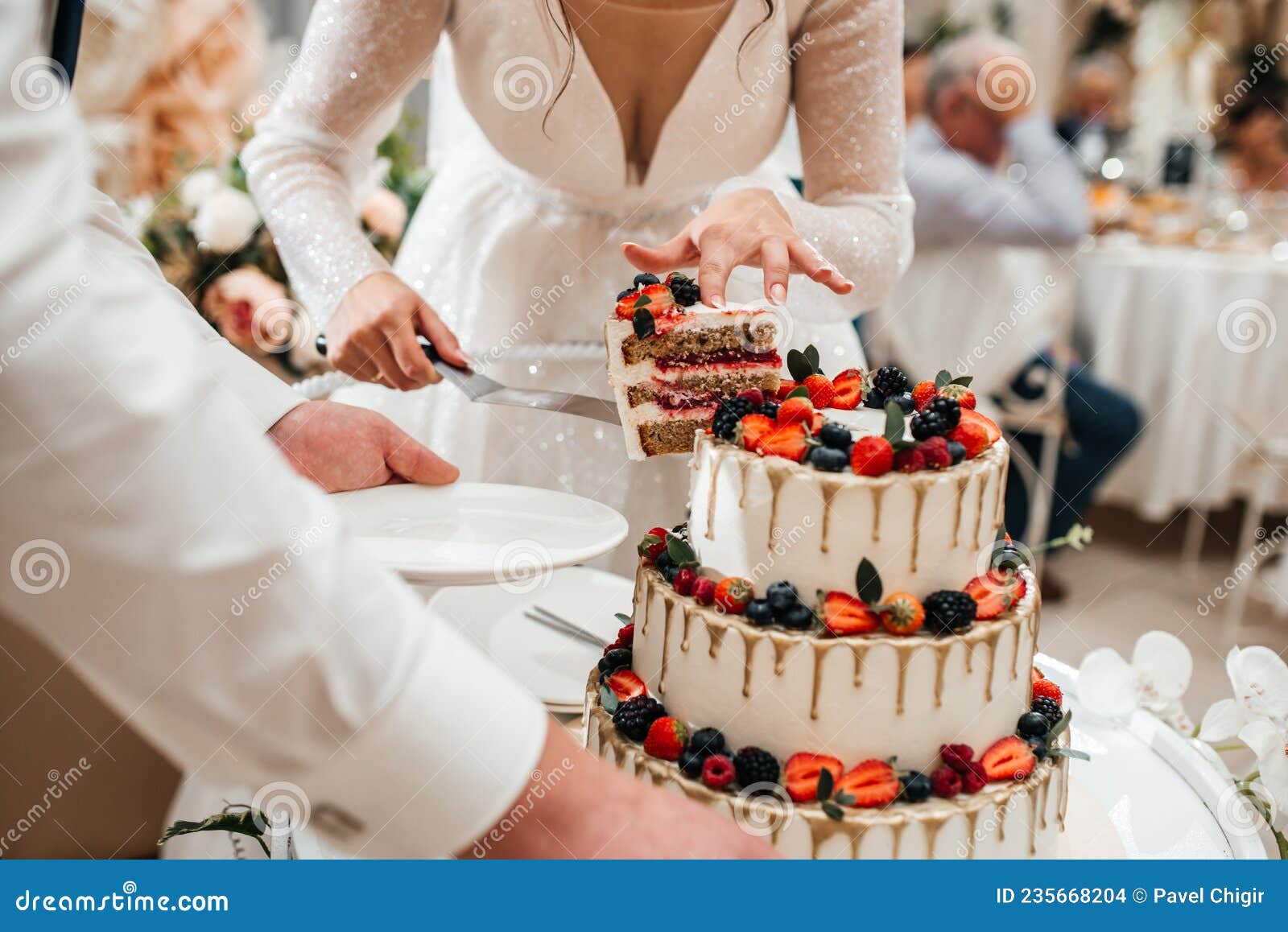 The Bride and Groom Cut the First Piece of the Wedding Cake Stock Photo ...