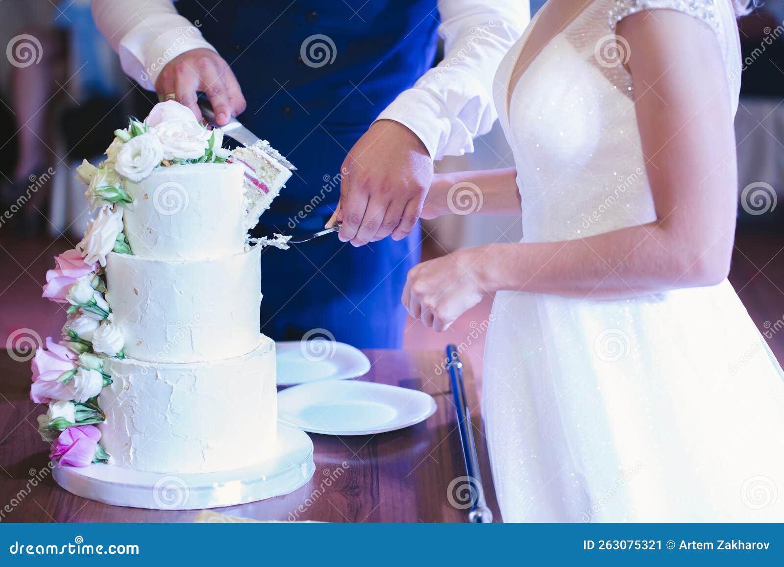 The Bride and Groom Cut a Gorgeous Wedding Cake at a Banquet. Stock ...
