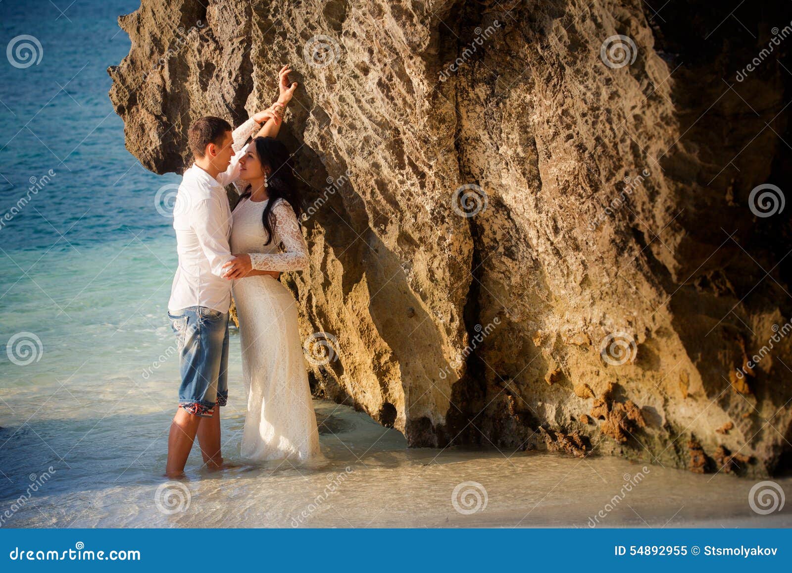 Bride and Groom Lean Against Rock Stock Image - Image of dawn, brunette ...