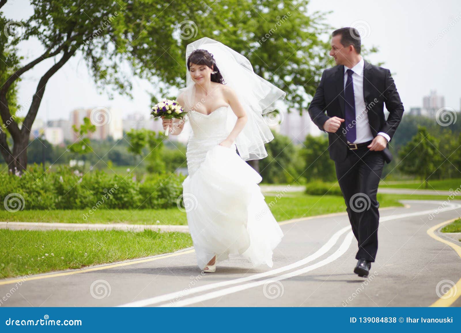 The Bride and Groom Run Together on an Asphalt Road Stock Photo - Image ...