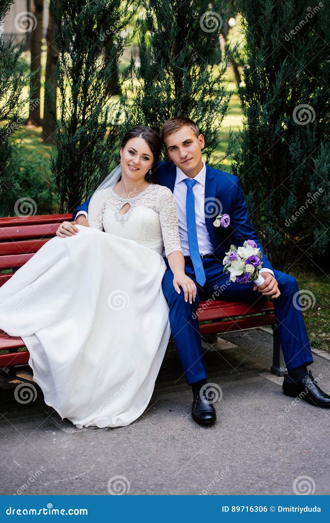 Bride and Groom Sit on a Bench. the Groom Hugs the Bride Stock Photo ...
