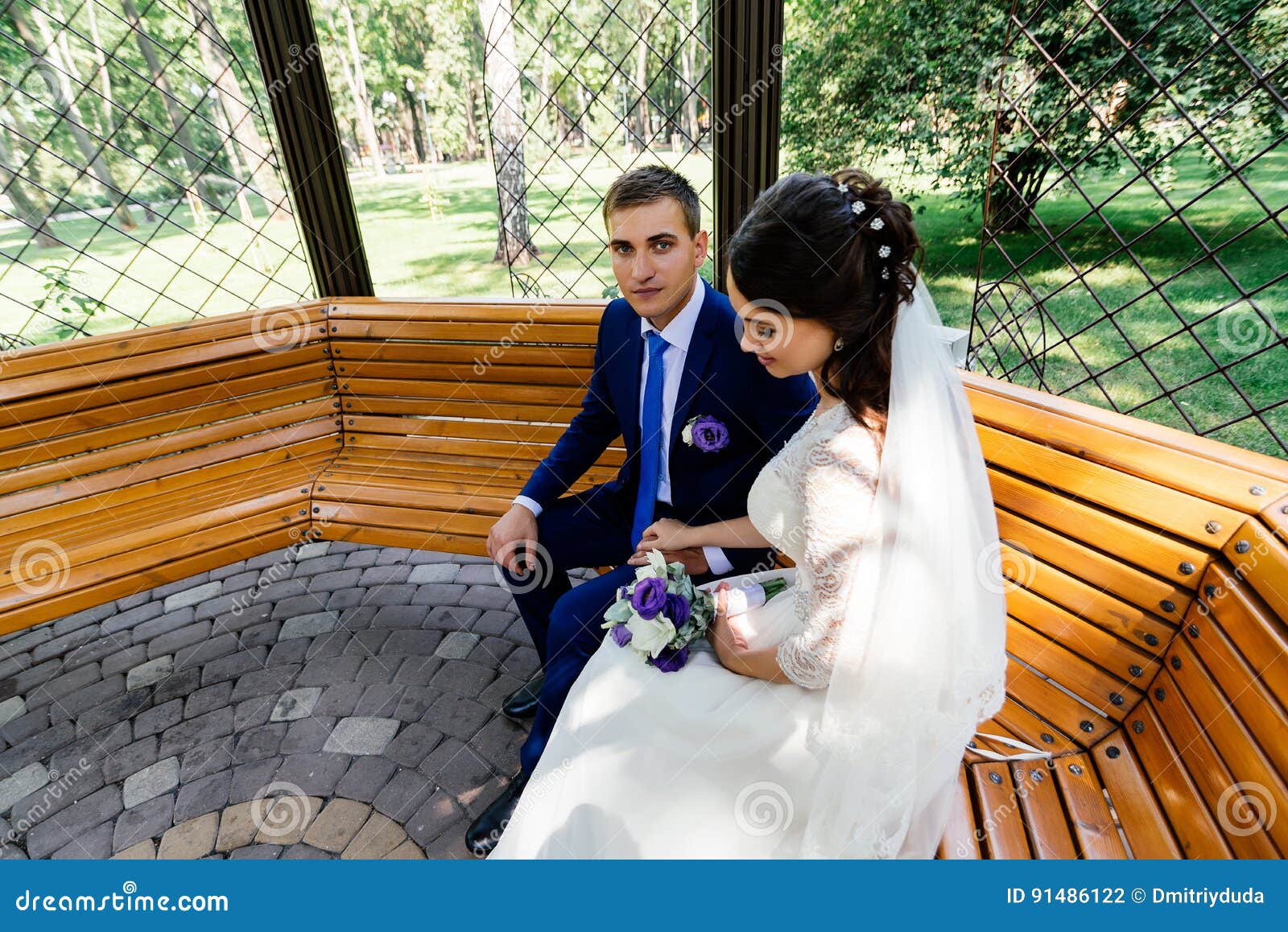The Bride and Groom Sit on a Bench Stock Photo - Image of female, grey ...