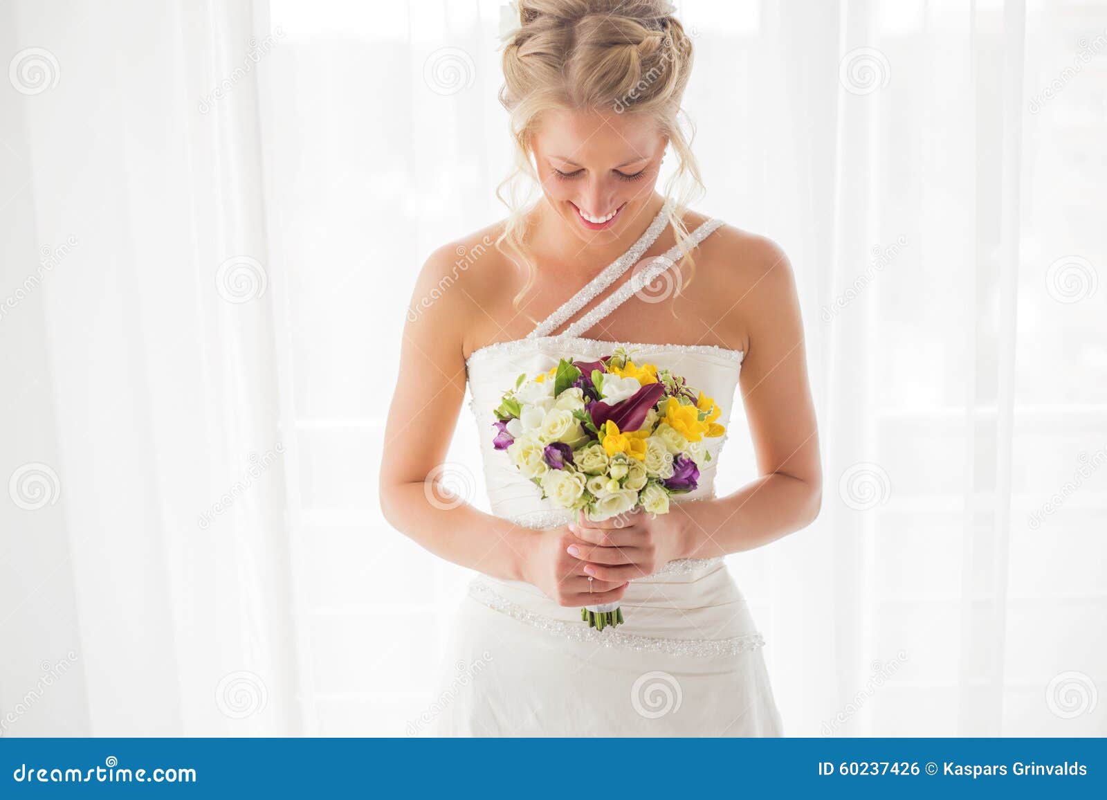 Bride Looking Down at Her Flowers Stock Photo - Image of gown, fashion ...