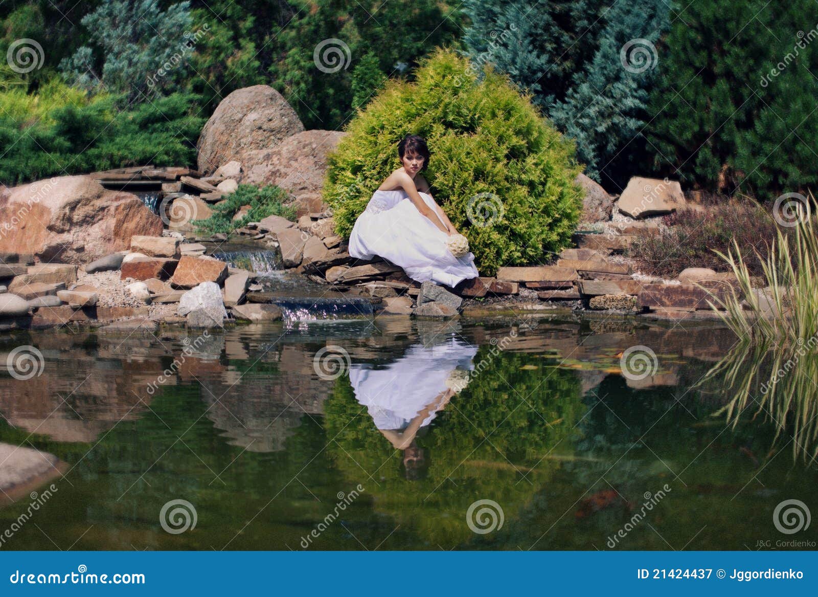 Bride poses on a pond stock image. Image of elegance - 21424437