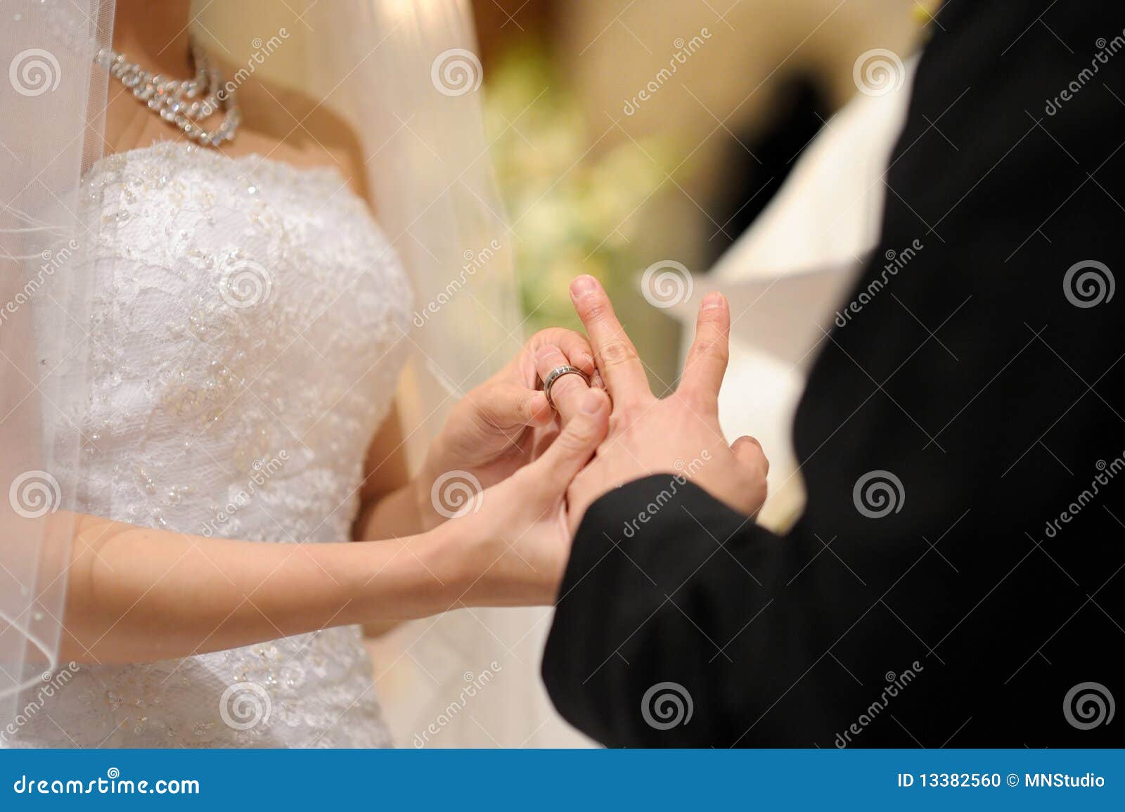 Bride Putting A Wedding Ring On The Finger Of Her Groom During A ...