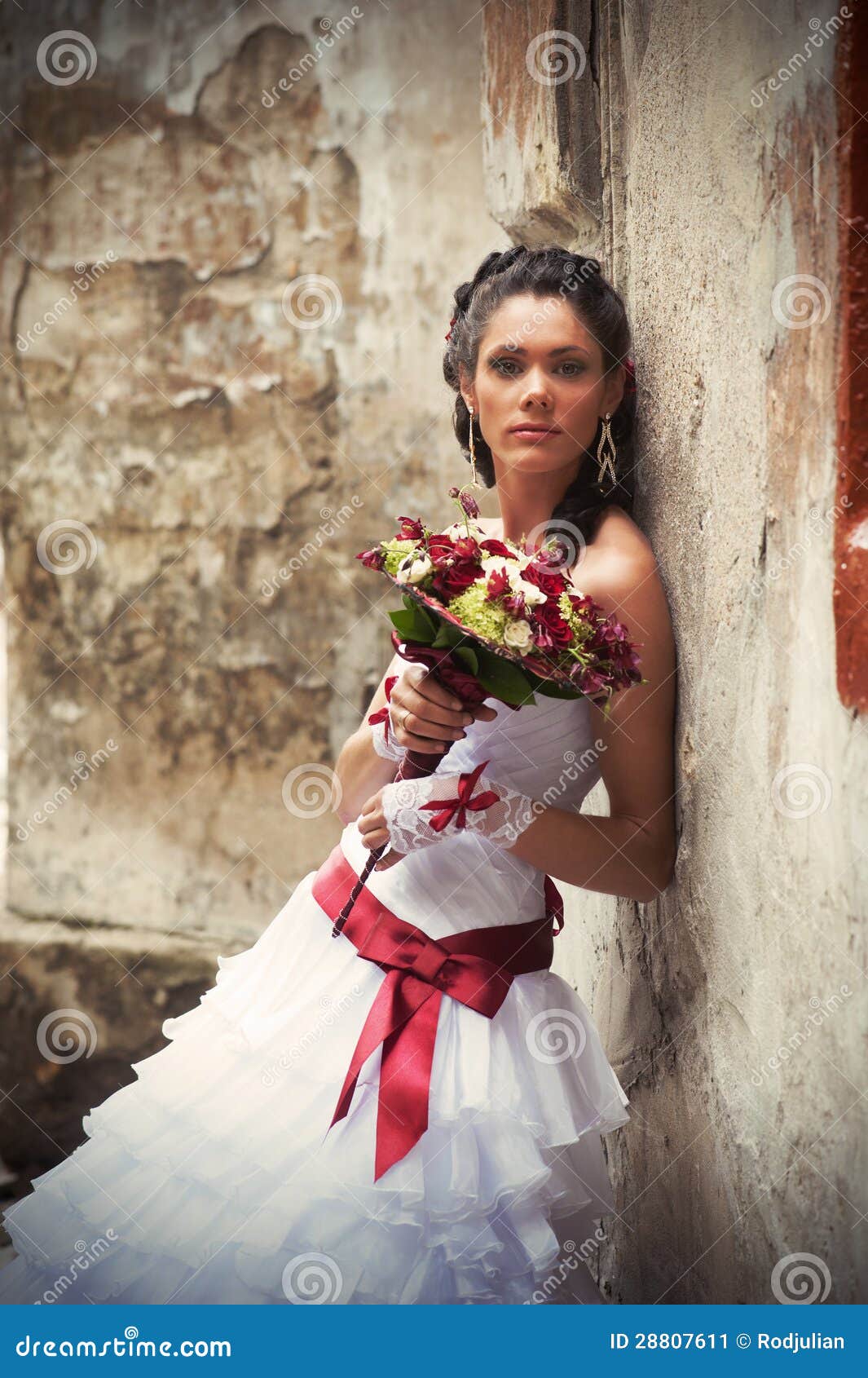 Bride with Wedding Bouquet Leaning Against the Wall Stock Image - Image ...