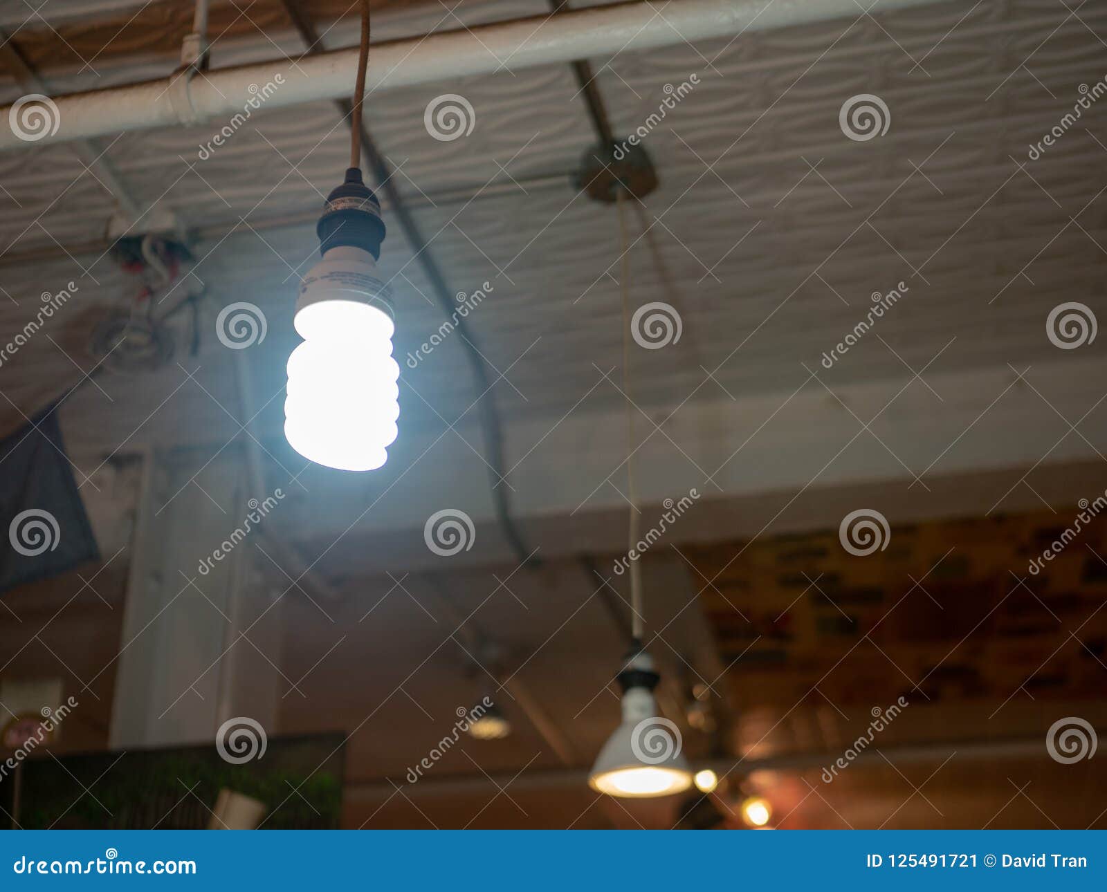 Bright Florescent Coil Light Bulb Hanging in Warehouse Stock Image ...