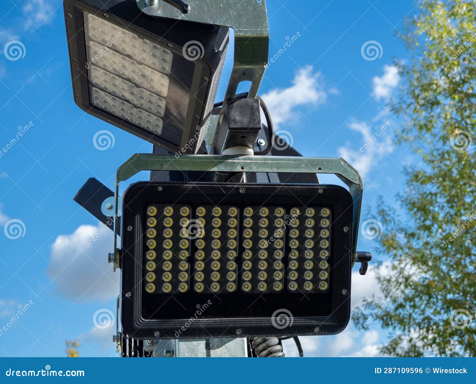 Traffic Lights are Set Up on a Green Pole with Trees in the Background ...