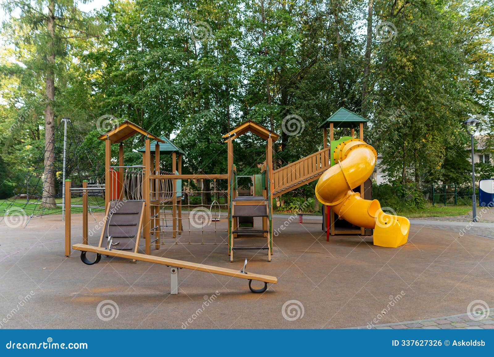 Bright Park Playground with Climbing Structures and Slide Surrounded by ...