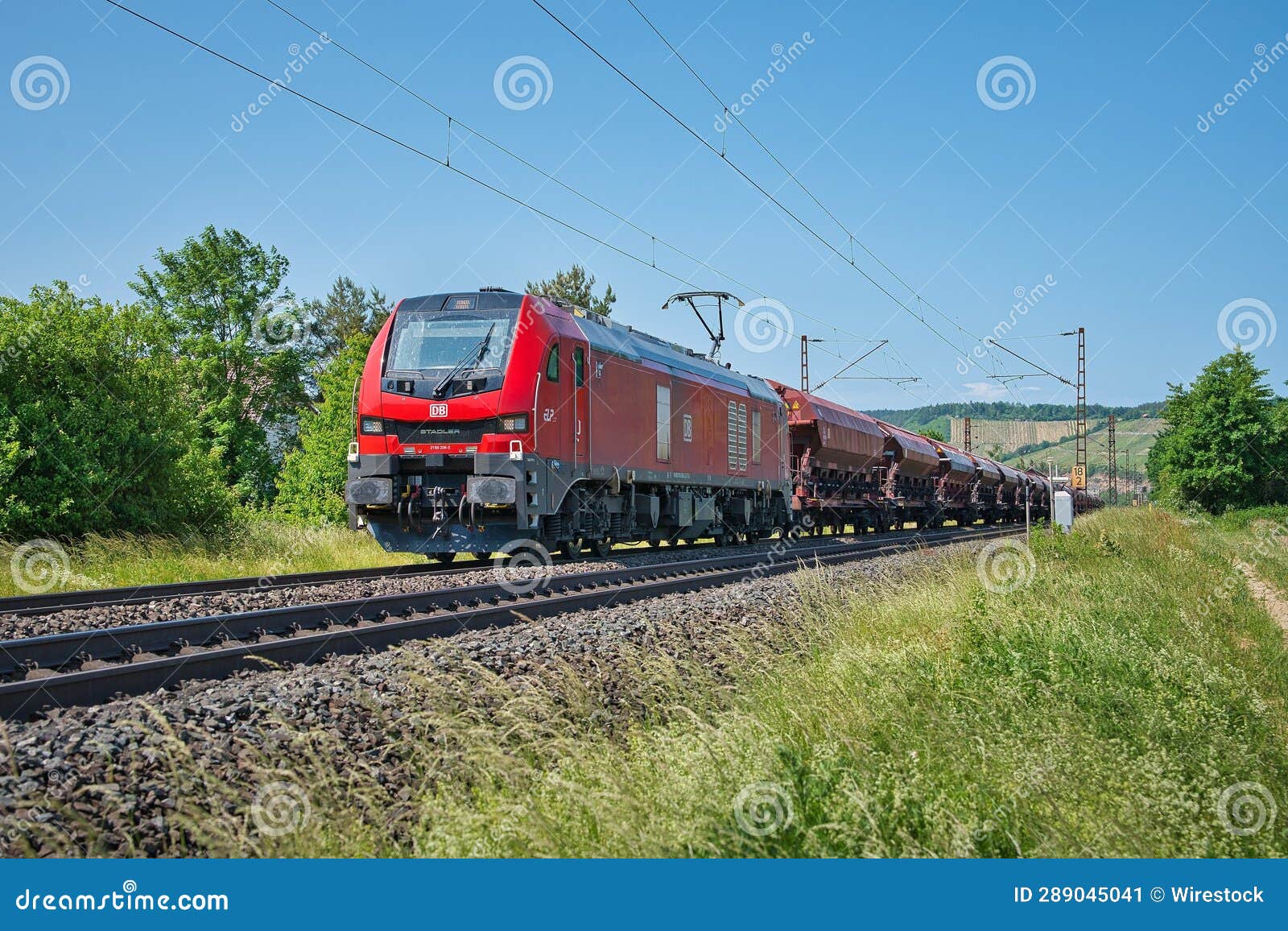 Bright Red Commuter Train Travelling Down the Railroad Tracks ...