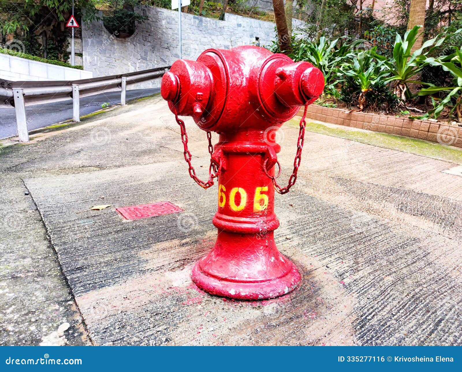 A Bright Red Fire Hydrant Stands on a Concrete Sidewalk, with a Chain ...