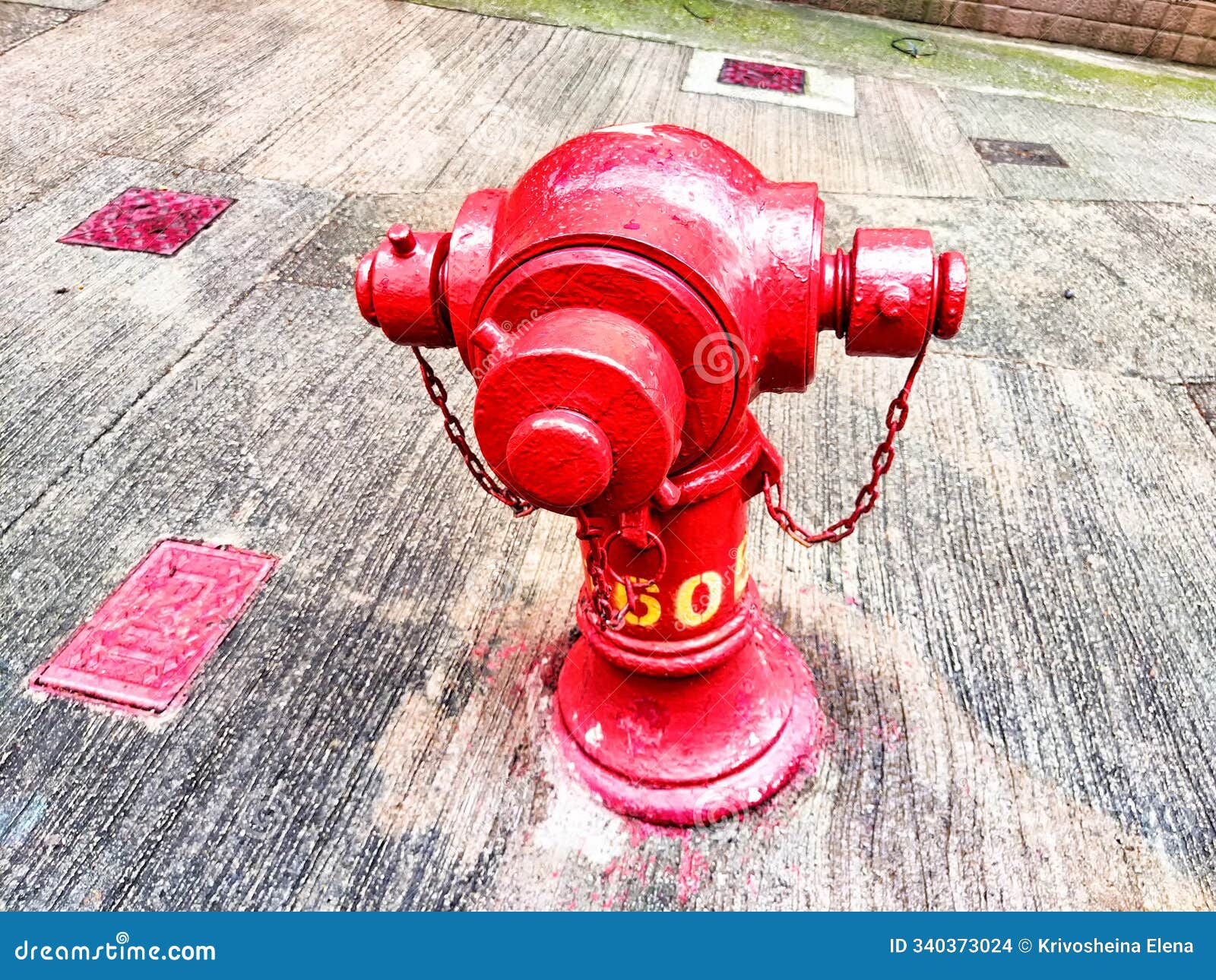 A Bright Red Fire Hydrant Stands on a Concrete Sidewalk, with a Chain ...