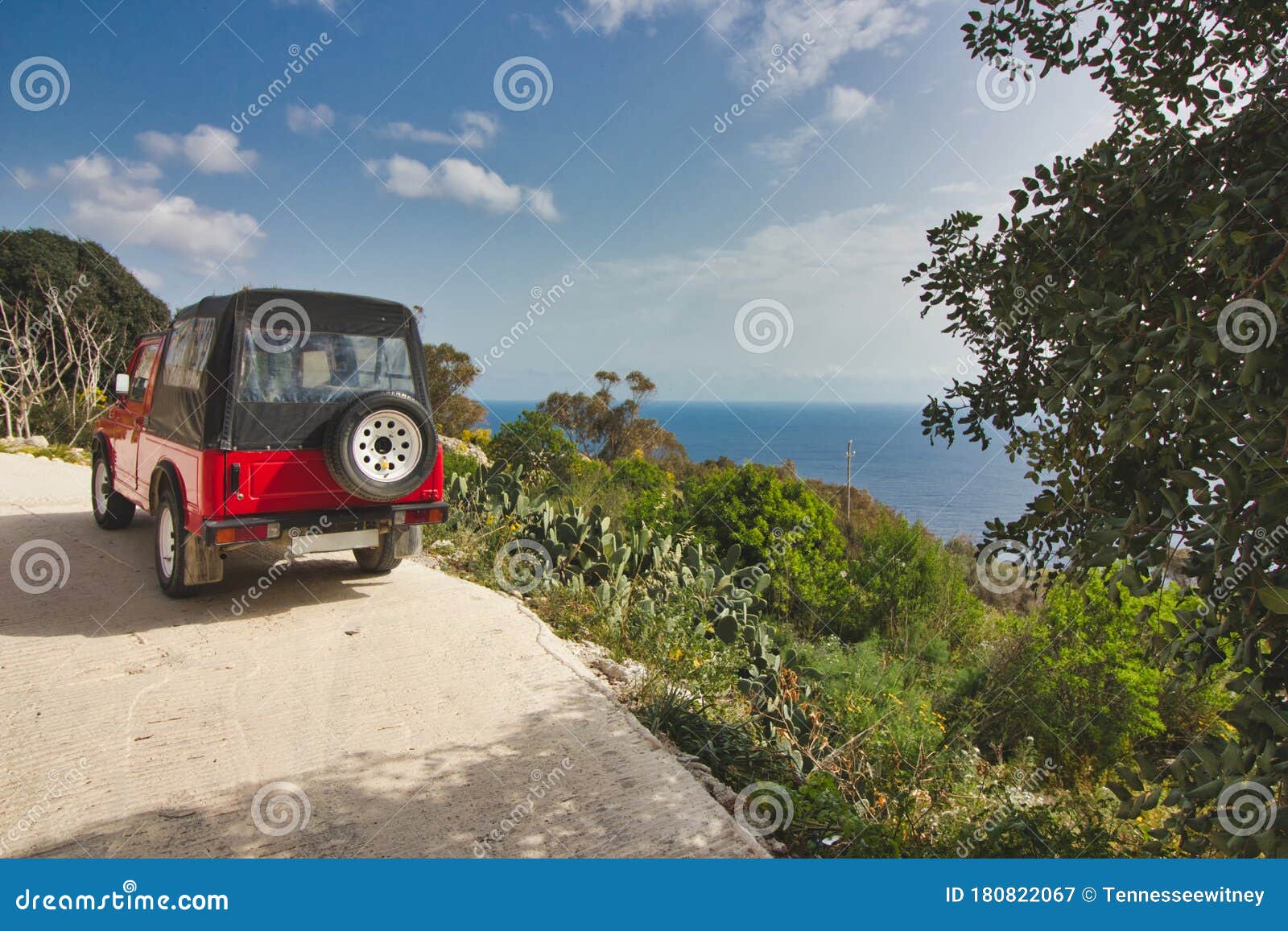 A Red Jeep on a Road on the Edge of a Cliff Overlooking the Sea Stock ...