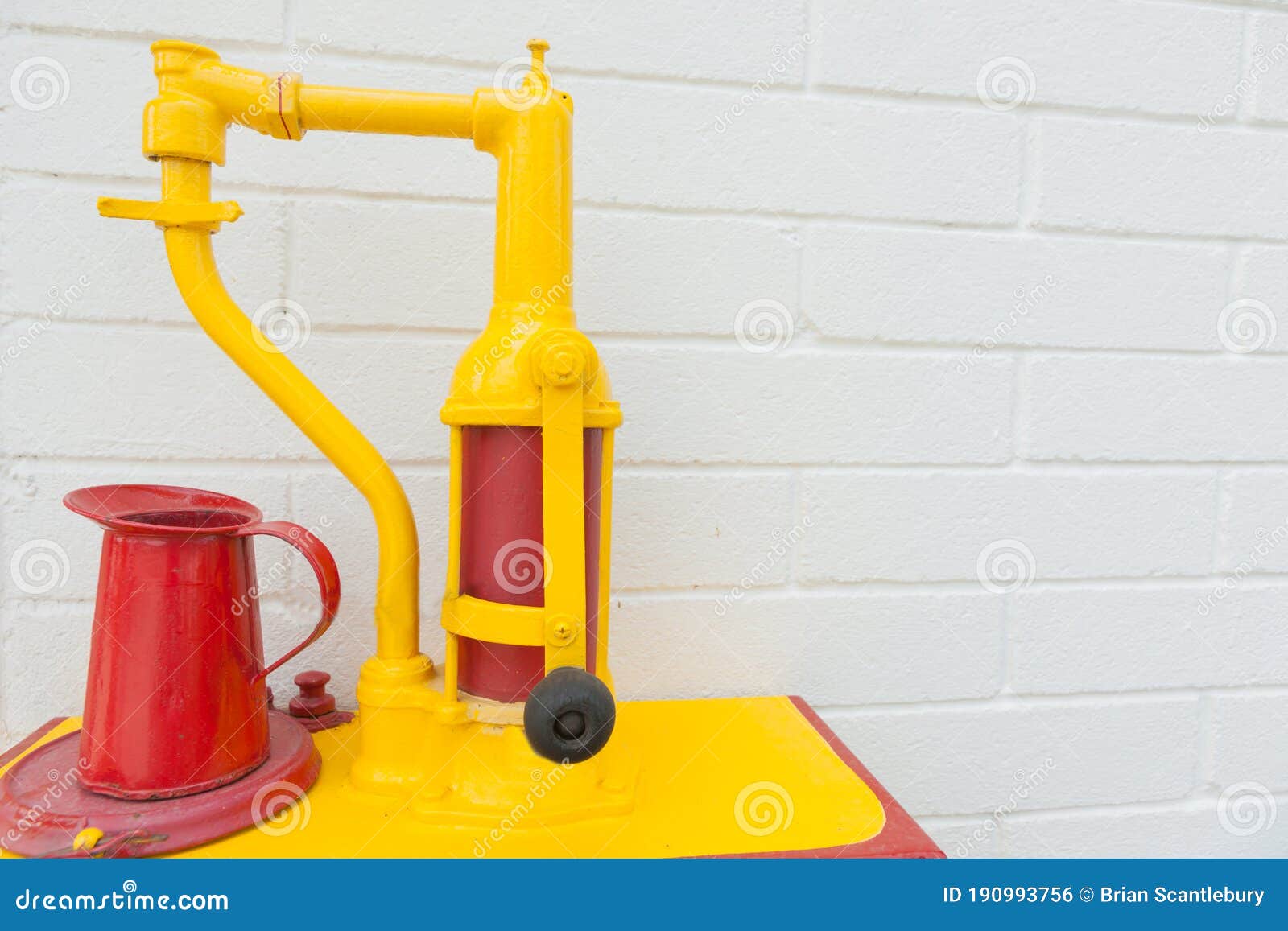 Bright Red Oil Can on Yellow Old-fashioned Oil Hand Pump Closeup ... Bright Red Oil Can on Yellow Old-fashioned Oil Hand Pump Closeup ...