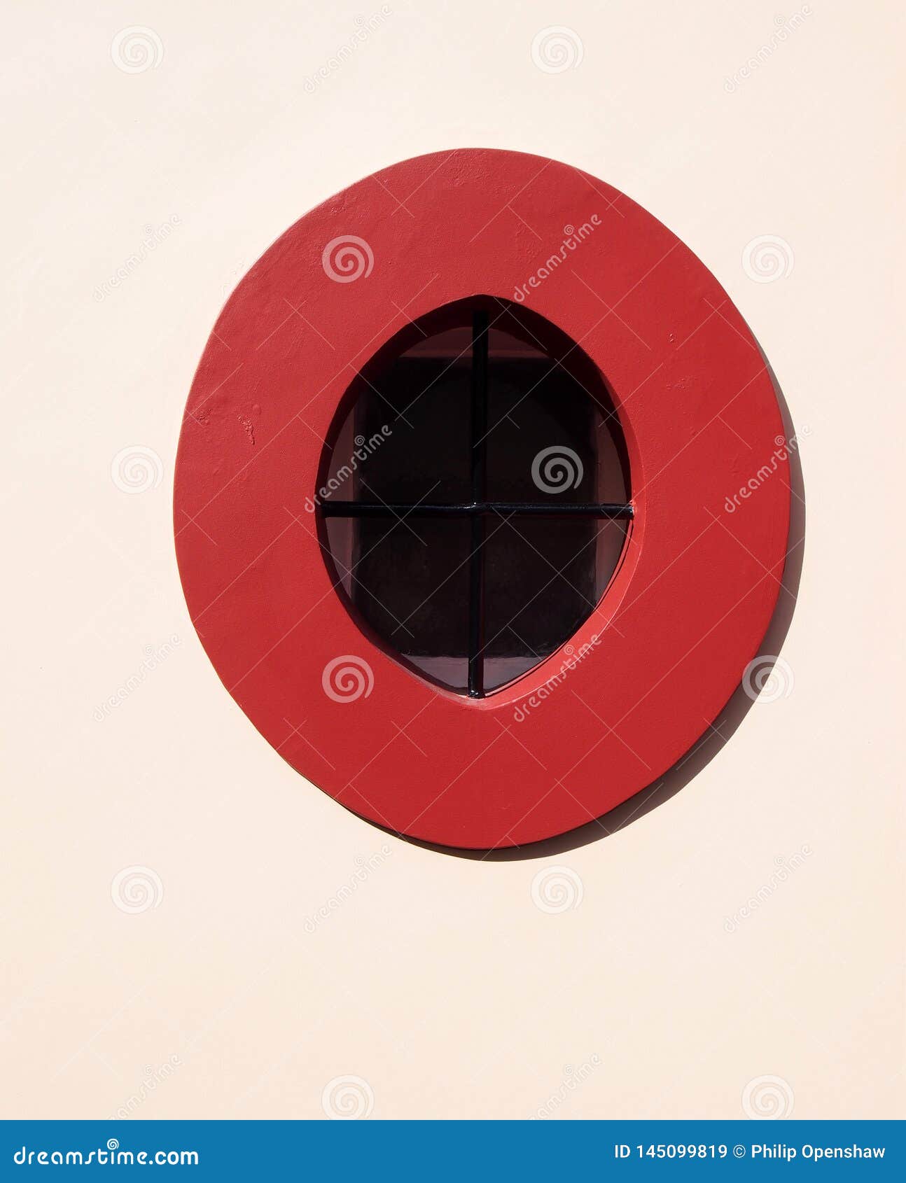 Bright Red Stone Oval Window Frame in a White Wall with Black Metal ...