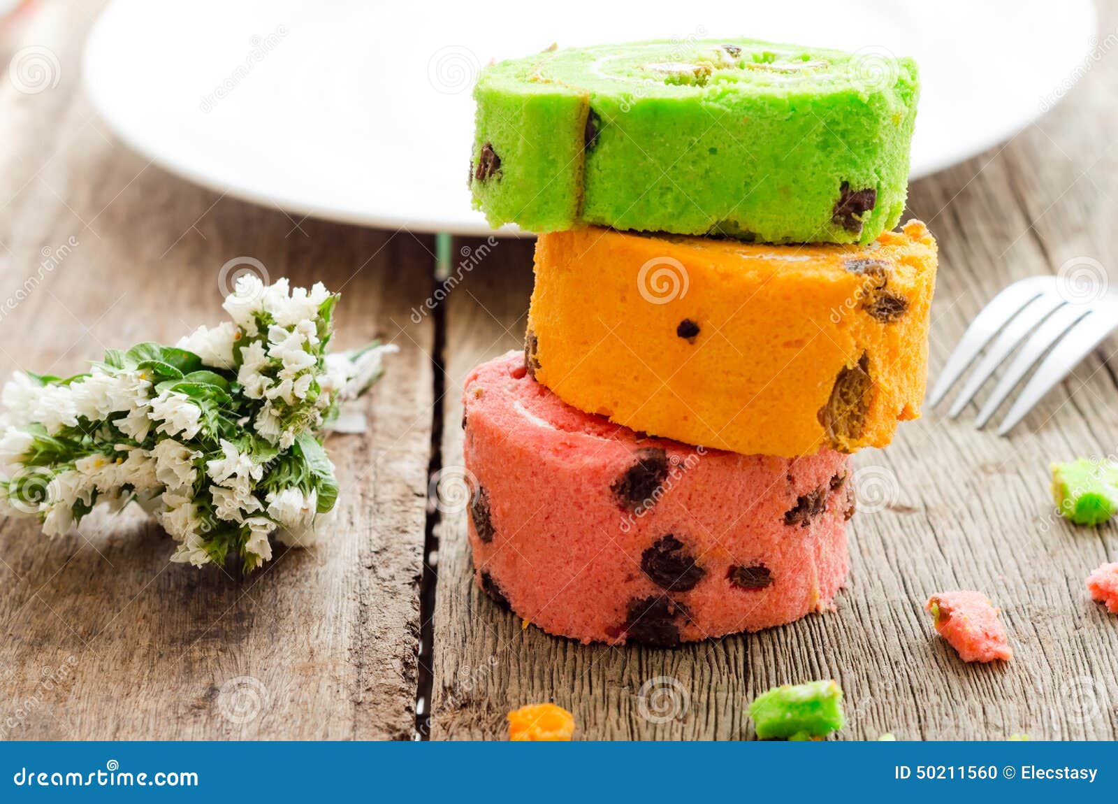 Bright Rolled Cake of Different Color on Wooden Table Stock Photo ...