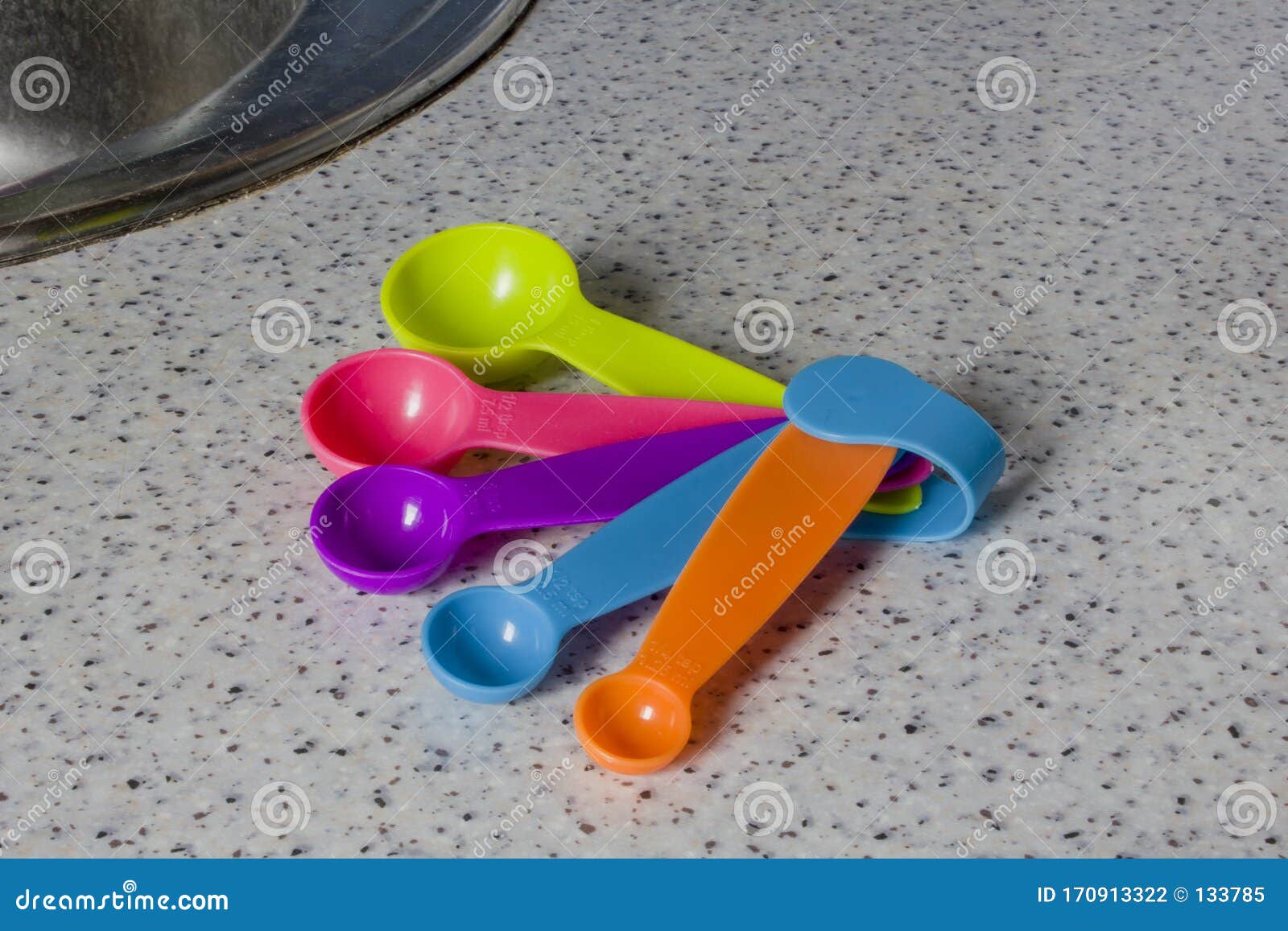 Bright Yellow Multicolored Plastic Measuring Spoons on a Gray Kitchen ...