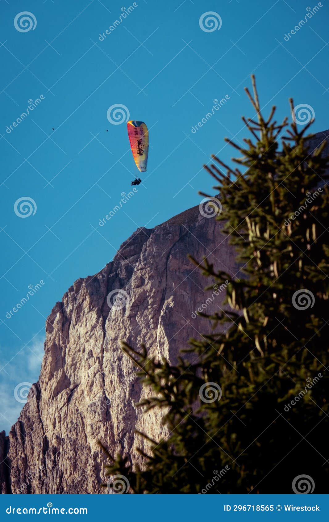 Brightly Colored Parasail Flying Over a Backdrop of Majestic Mountains ...