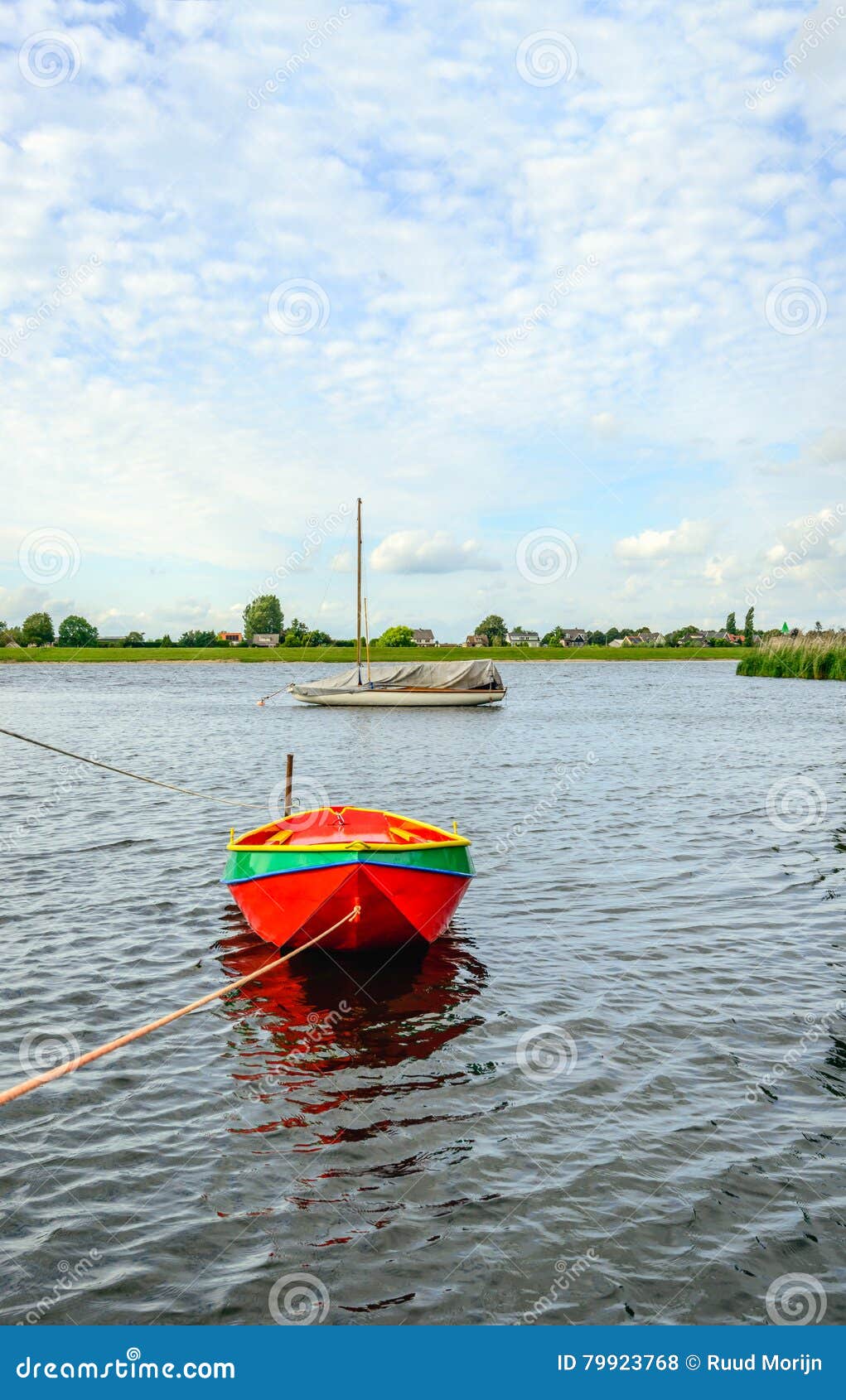 Brightly Colored Rowing Boat Moored To an Iron Pole in the Water Stock ...