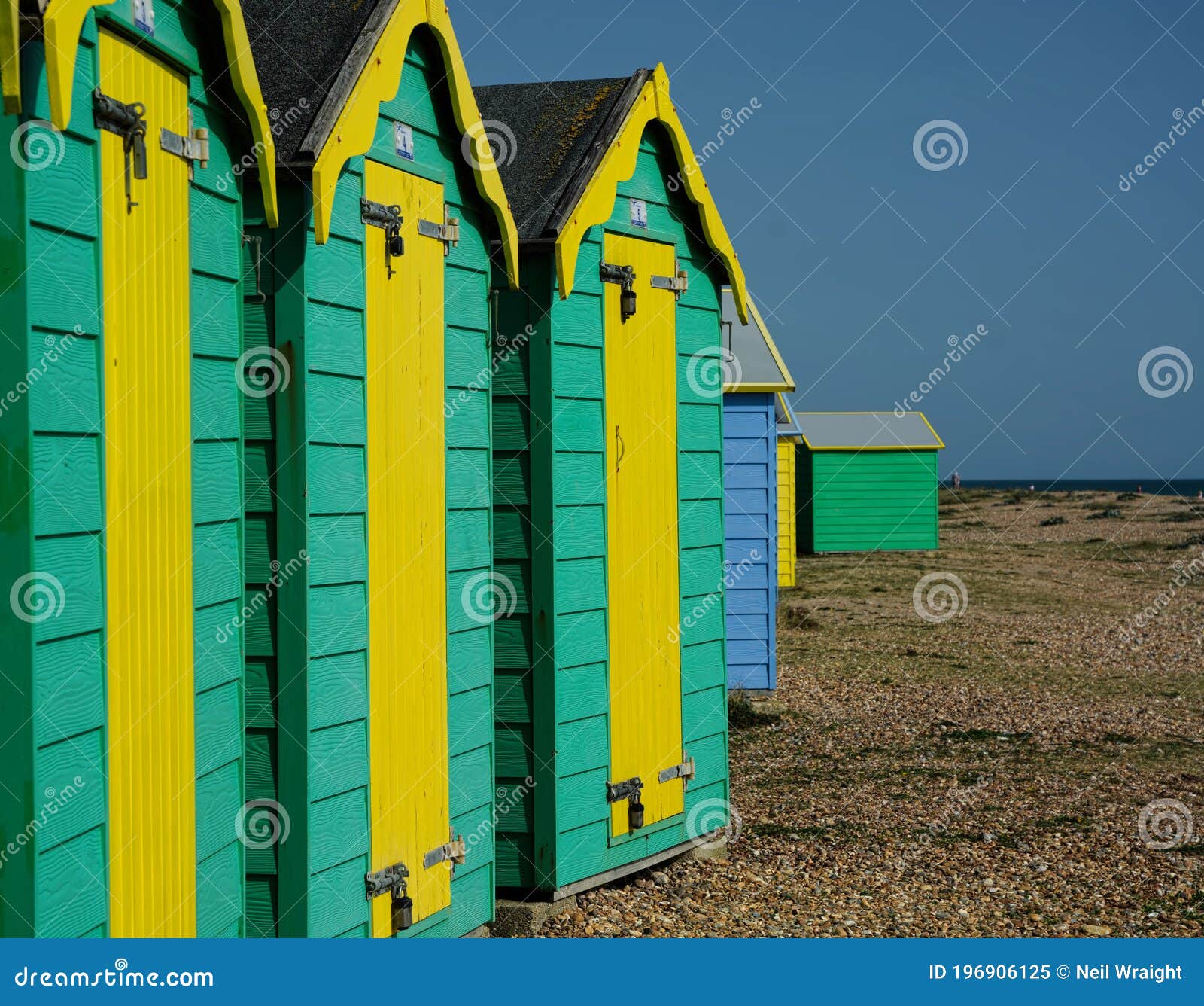 Brightly Colored Turquoise & Yellow Beach Huts. Deep Blue Sky, Pebble ...