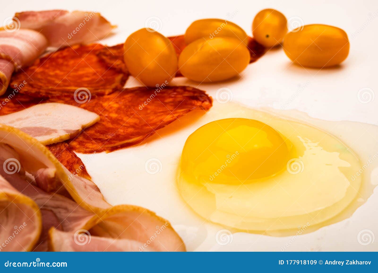 A Broken Chicken Egg without a Shell, Slices of Bacon and Sausage and ...
