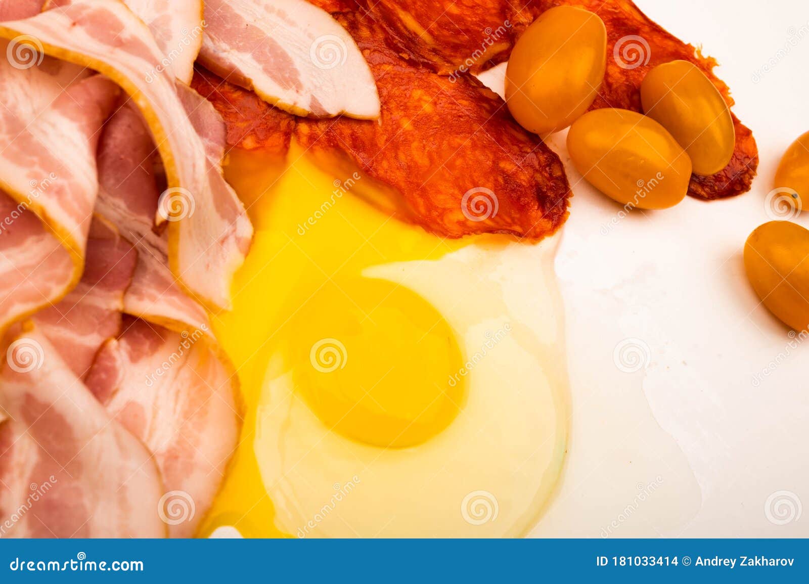 A Broken Chicken Egg without a Shell, Slices of Sausage and Bacon and ...